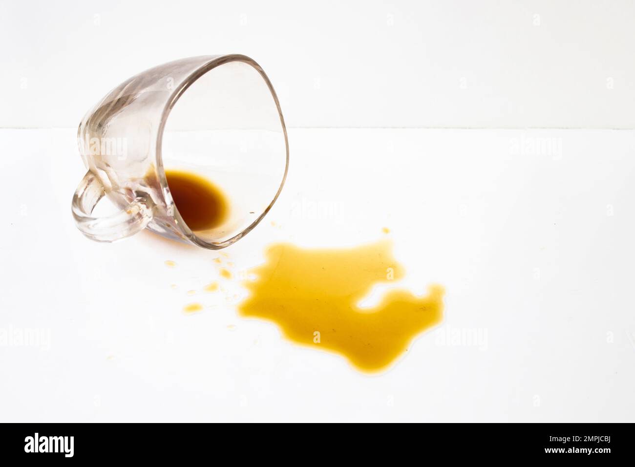 Coffee spill from a transparent glas cup on white background, soft ...