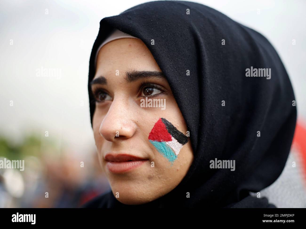 A Palestinian woman painted on her face a Palestinian flag during a ...