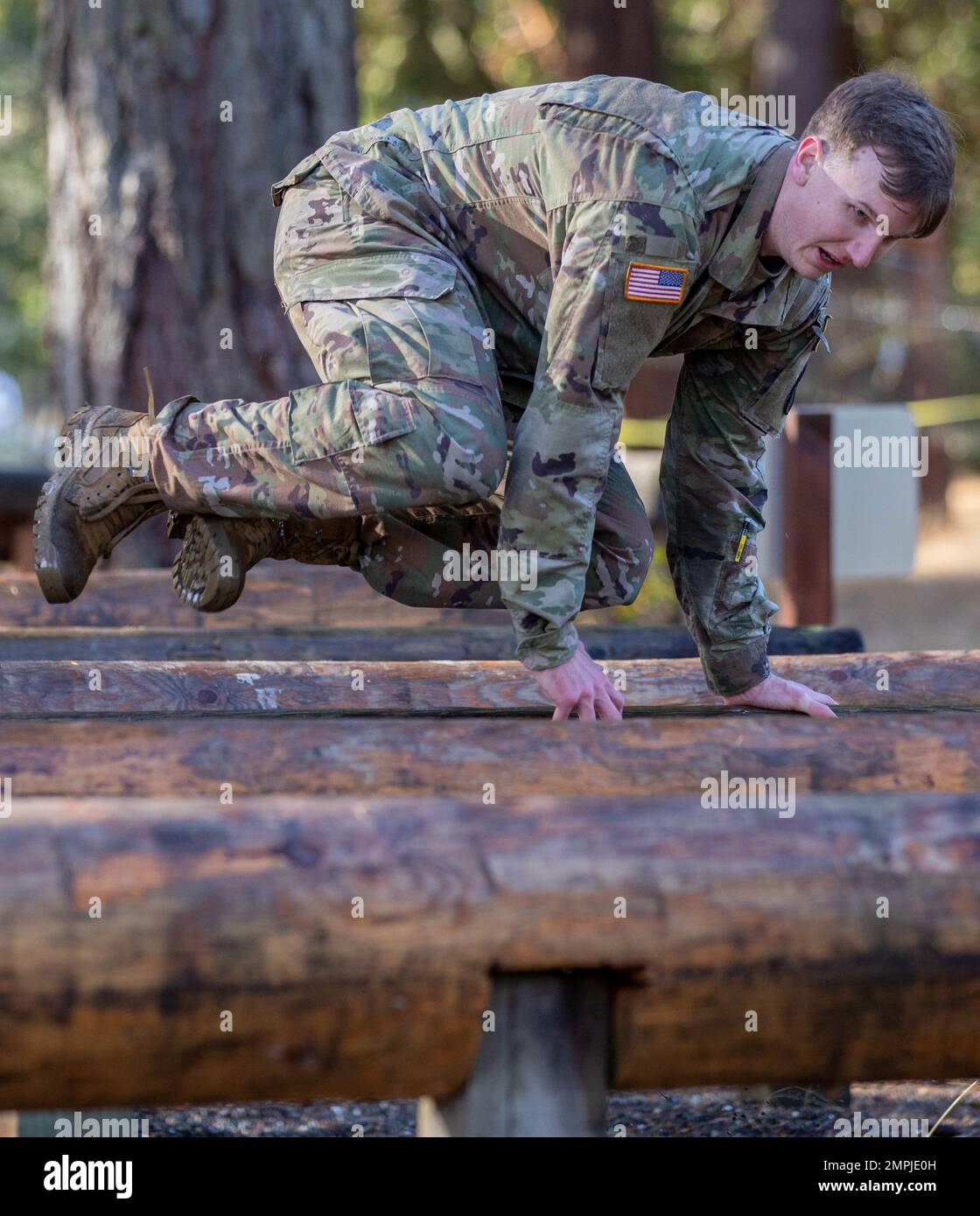 U.S. Army 1st Lt. Austin Pinkerton jumps over a log during the obstacle ...