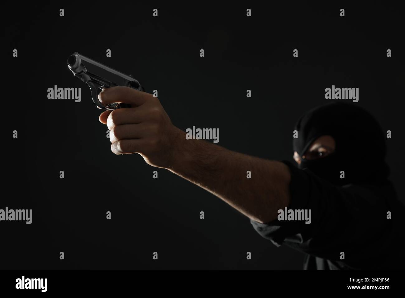 Professional killer on black background, focus on gun Stock Photo - Alamy