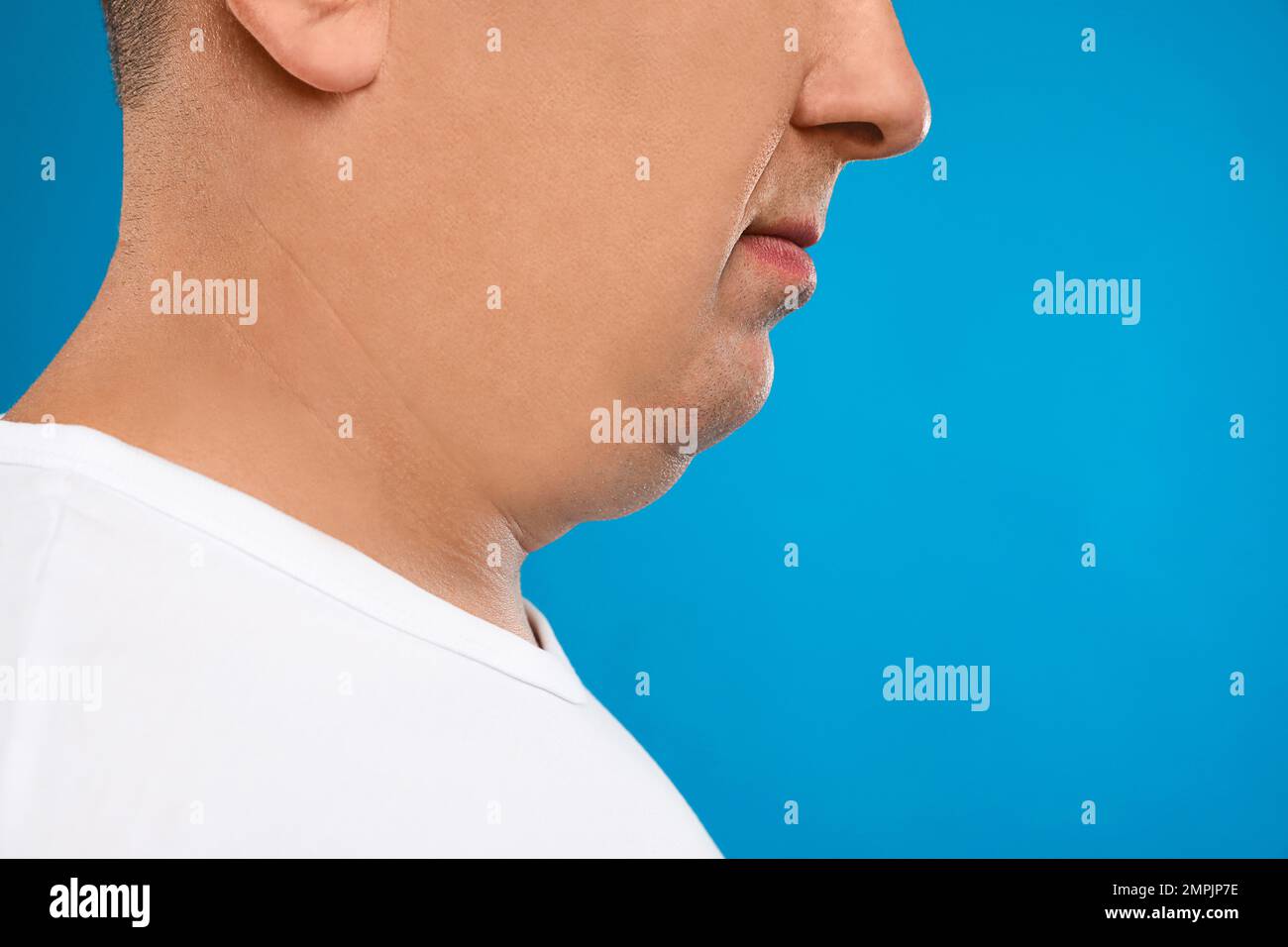 Mature man with double chin on blue background, closeup Stock Photo - Alamy