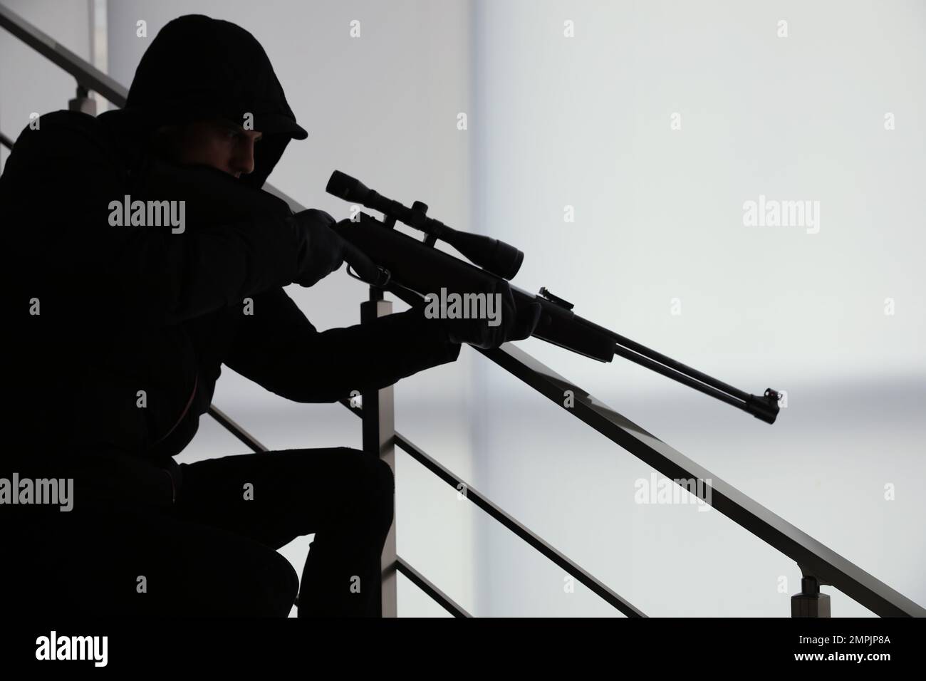 Hired professional killer with sniper rifle indoors Stock Photo - Alamy