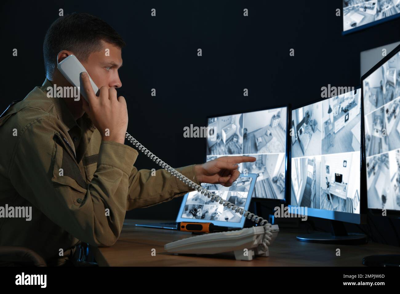 Security guard talking on telephone at workplace Stock Photo - Alamy