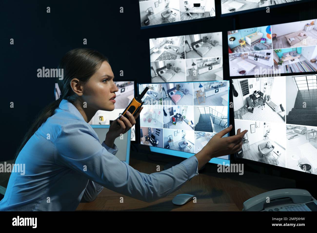 Security guard with portable transmitter monitoring modern CCTV cameras ...