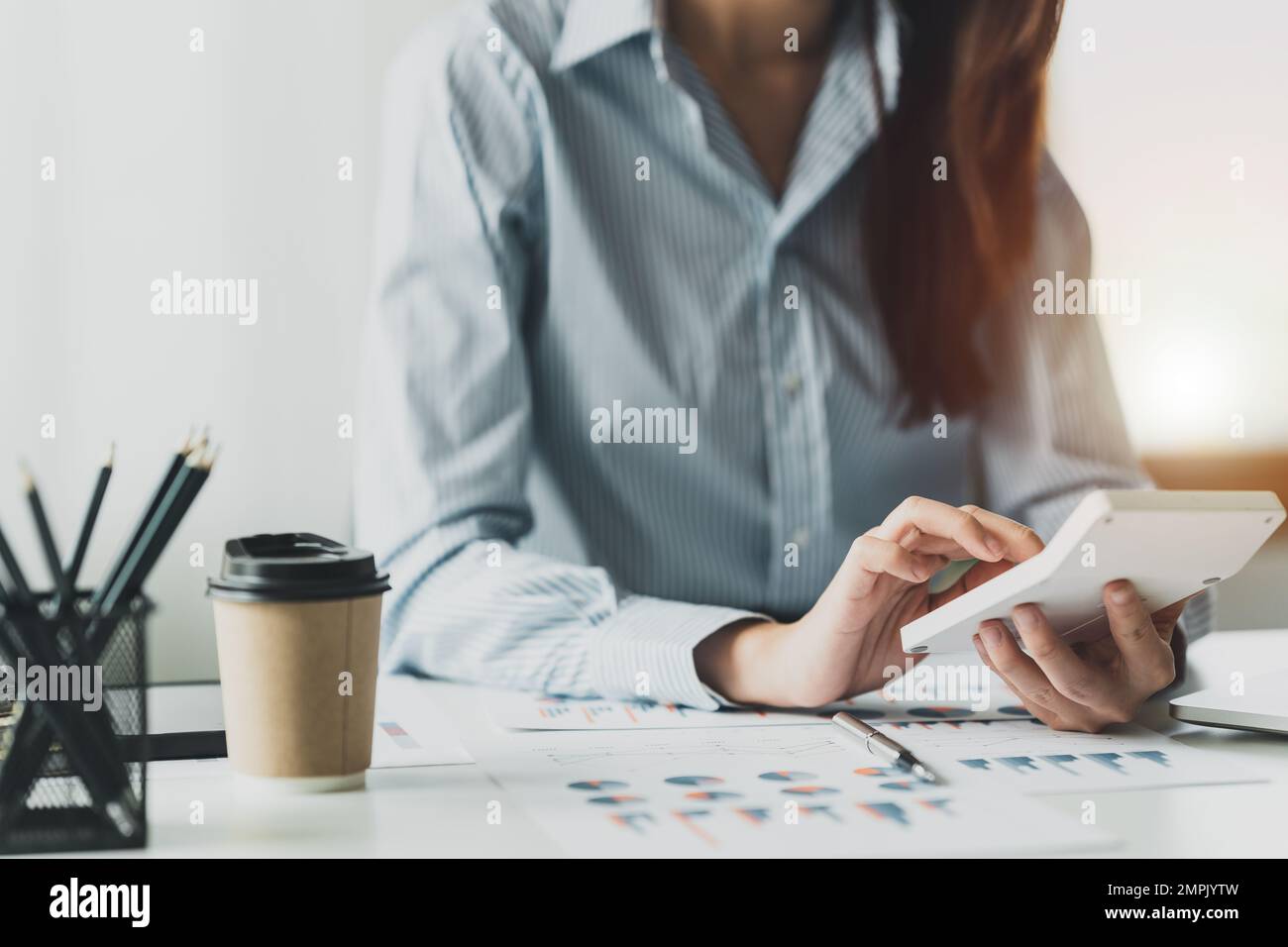 Asian Business Woman or Accountant do math and analyze with calculator ...