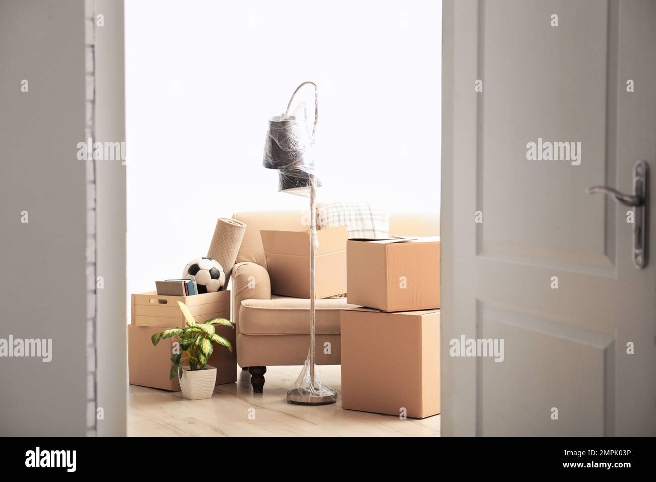 Cardboard boxes and household stuff in living room. Moving day Stock ...