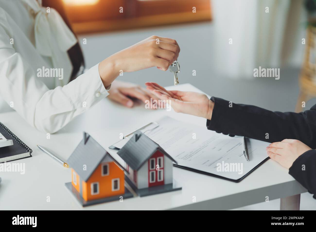 The real estate agent or agency giving house key to customer after ...