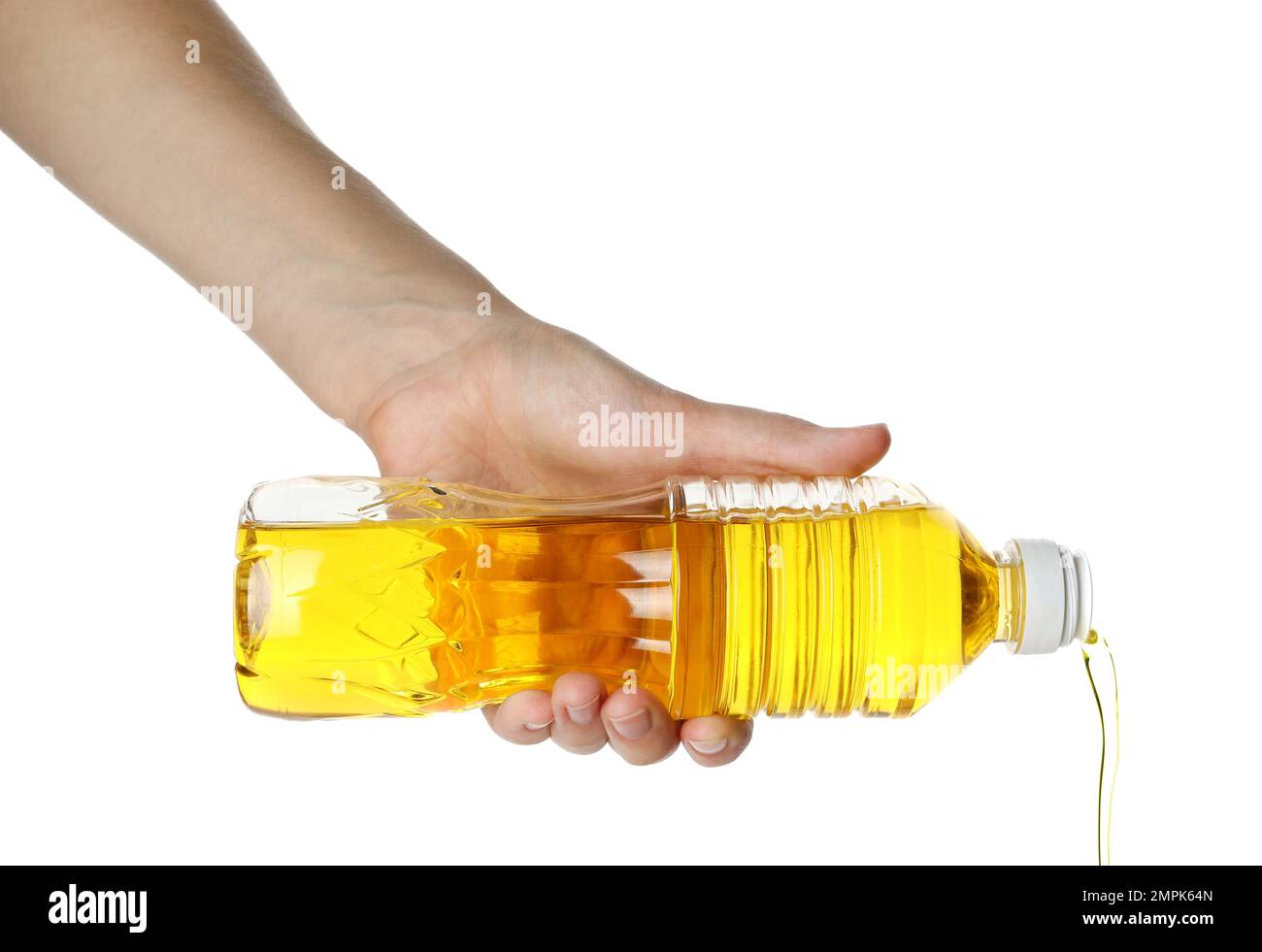 Woman pouring cooking oil from bottle on white background, closeup ...