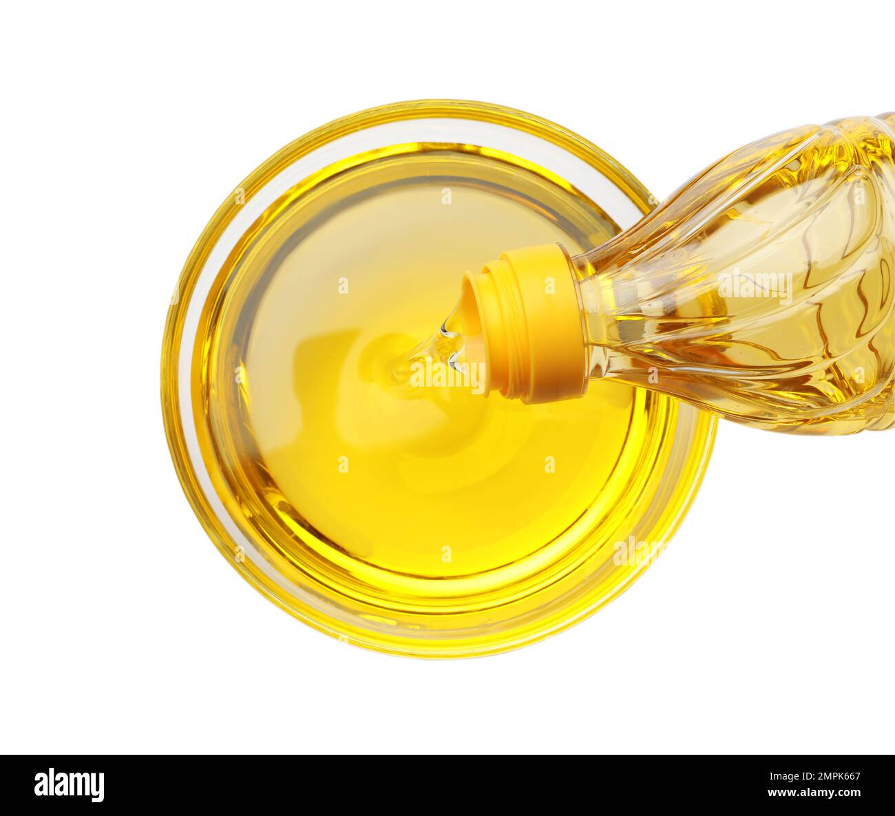 Pouring cooking oil from bottle into bowl isolated on white, top view ...