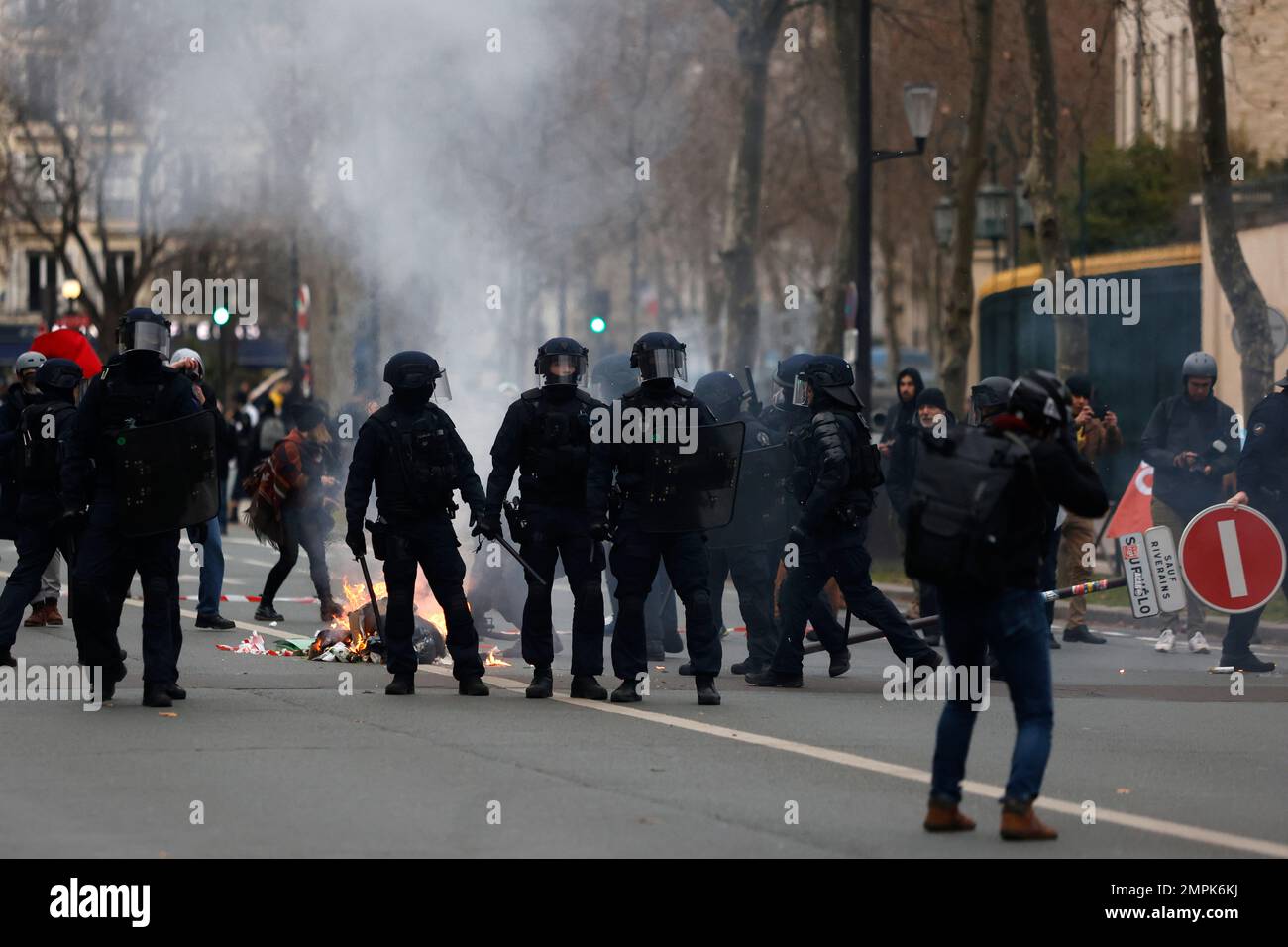 Riot police officers advance during incidents as part of a ...