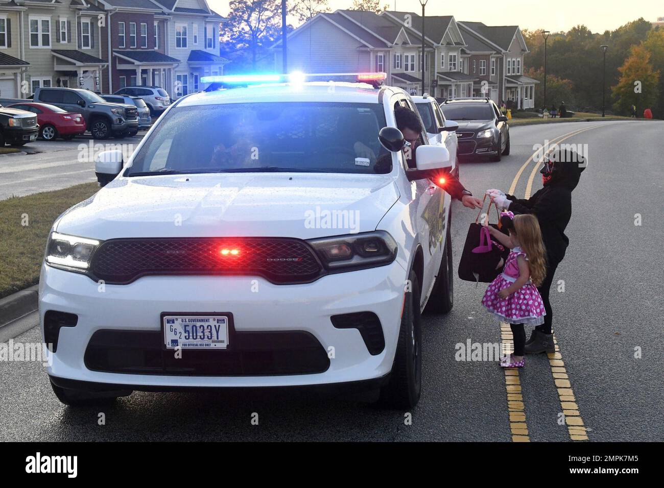 A Fort Jackson police officer hands out candy to trick or treaters in ...
