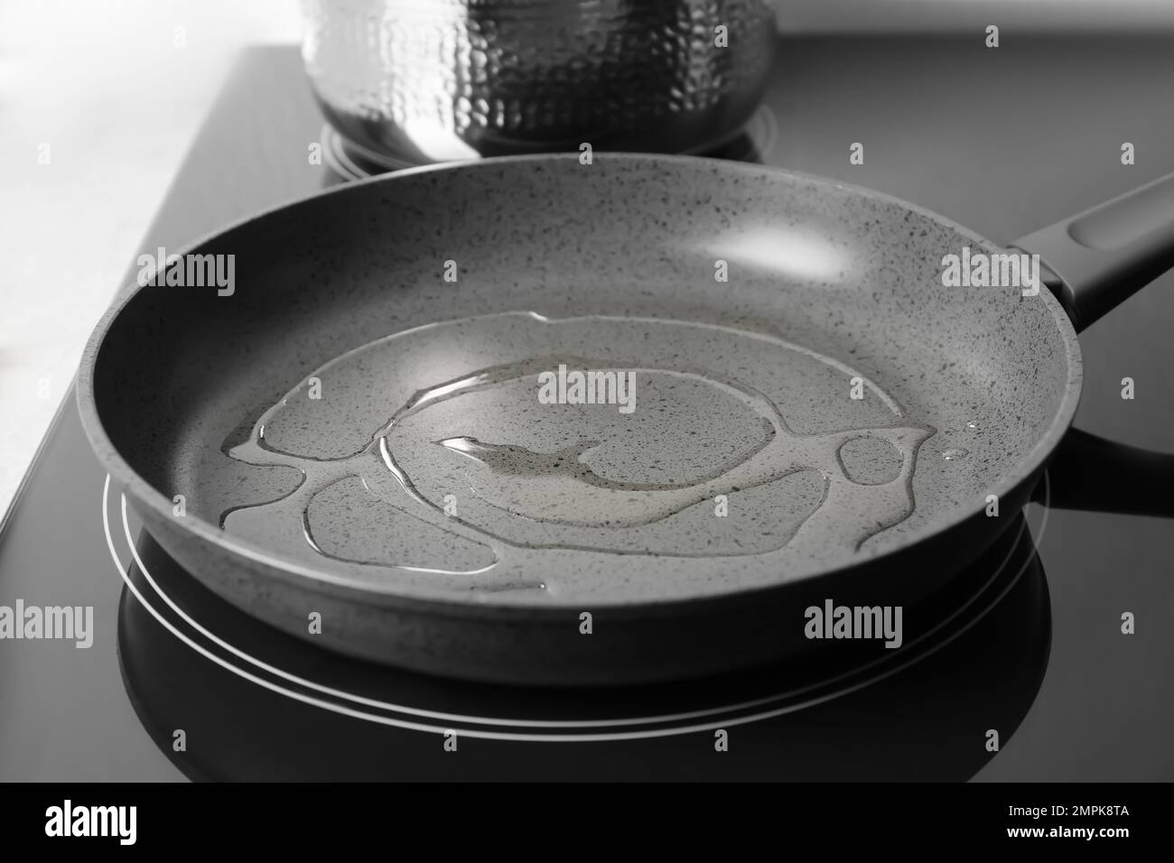 Frying pan with cooking oil on induction stove Stock Photo - Alamy