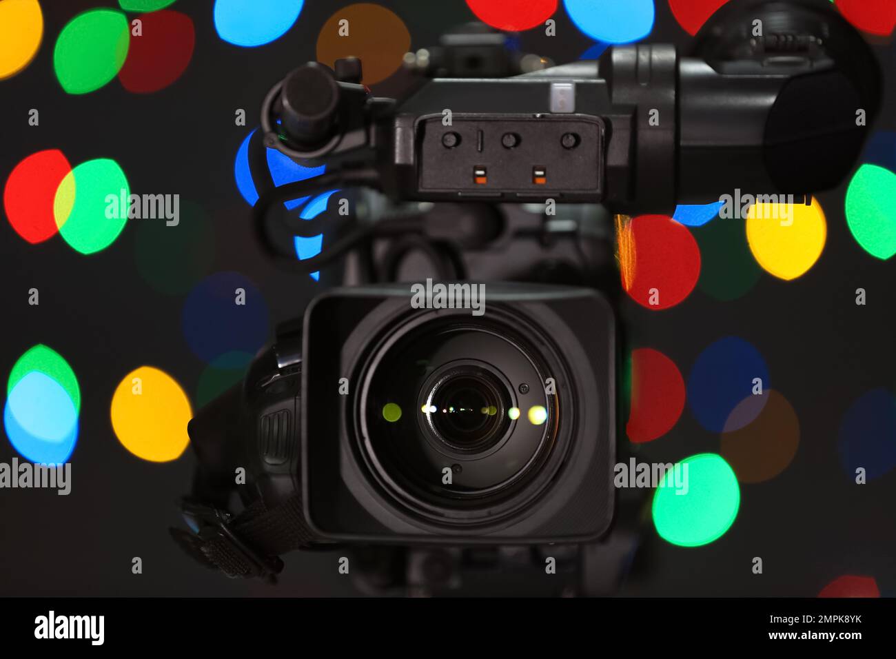Modern video camera against blurred colorful lights Stock Photo - Alamy