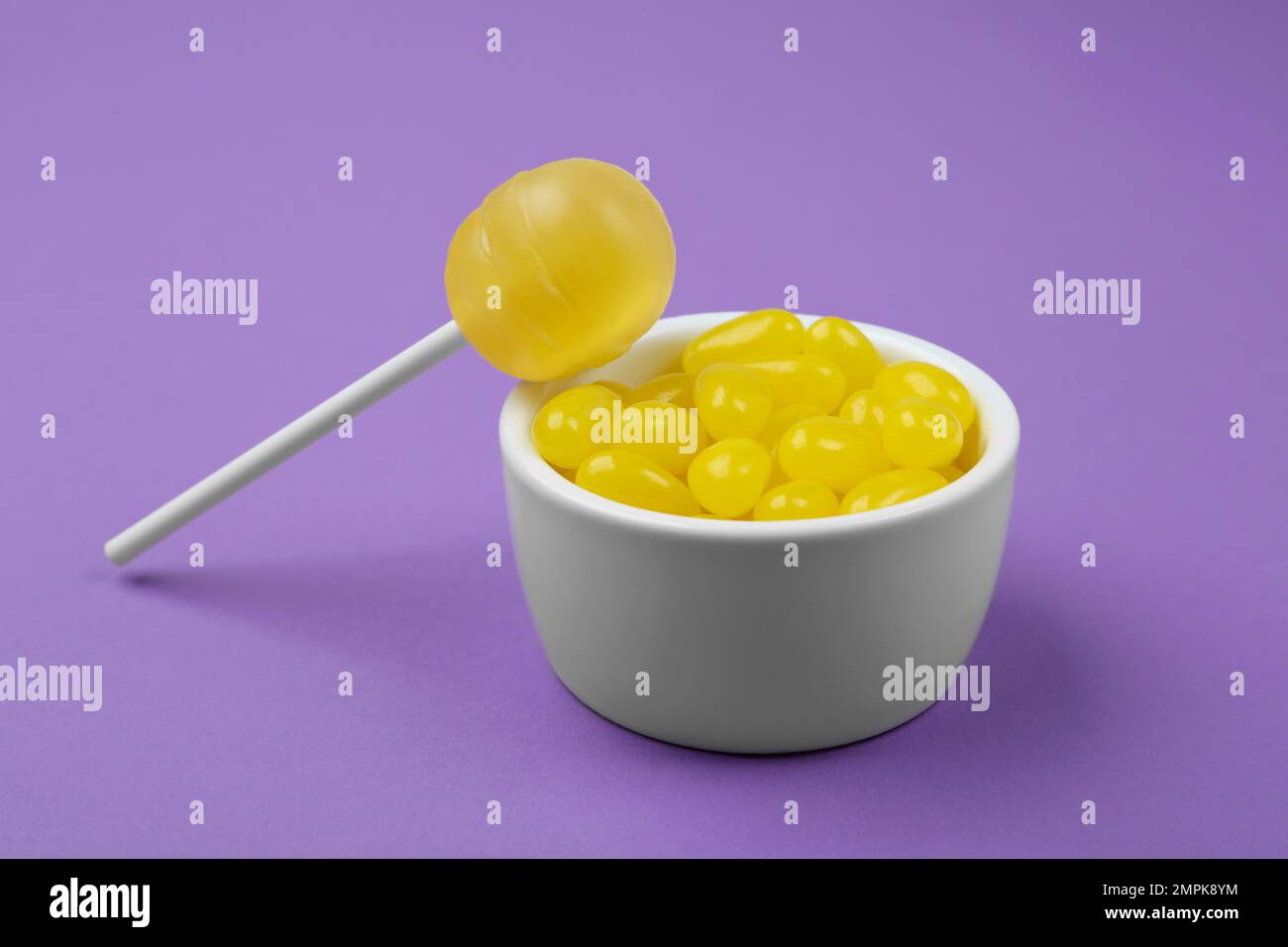 Different lemon flavored candies on purple background Stock Photo - Alamy