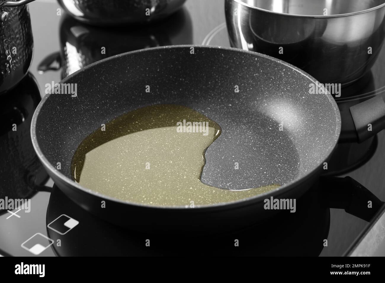 Frying pan with cooking oil on induction stove Stock Photo - Alamy