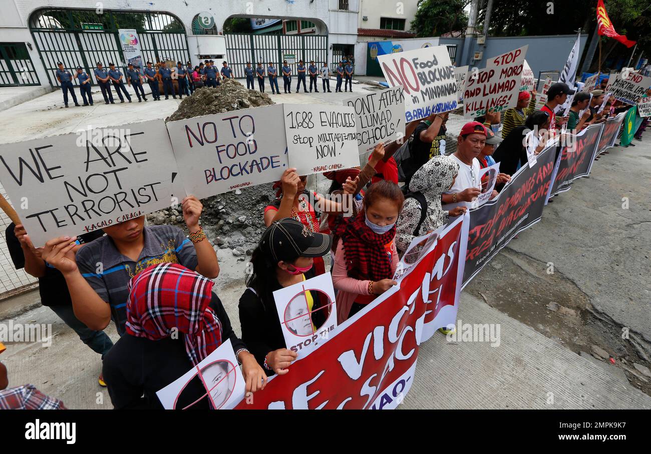 Protesters shout slogans while displaying placards during a rally ...