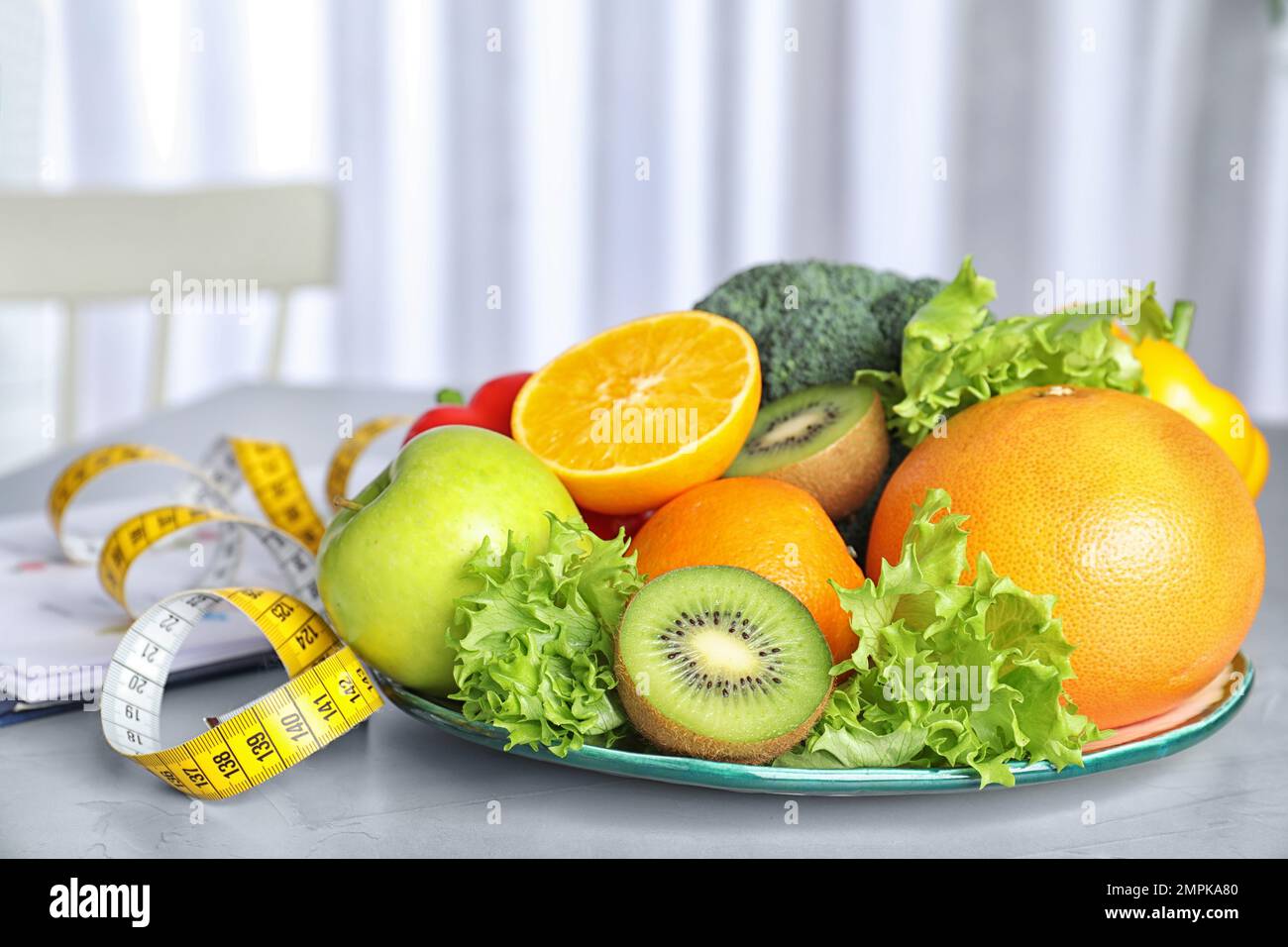 Measuring tape, vegetables and fruits on table. Diet plan from ...