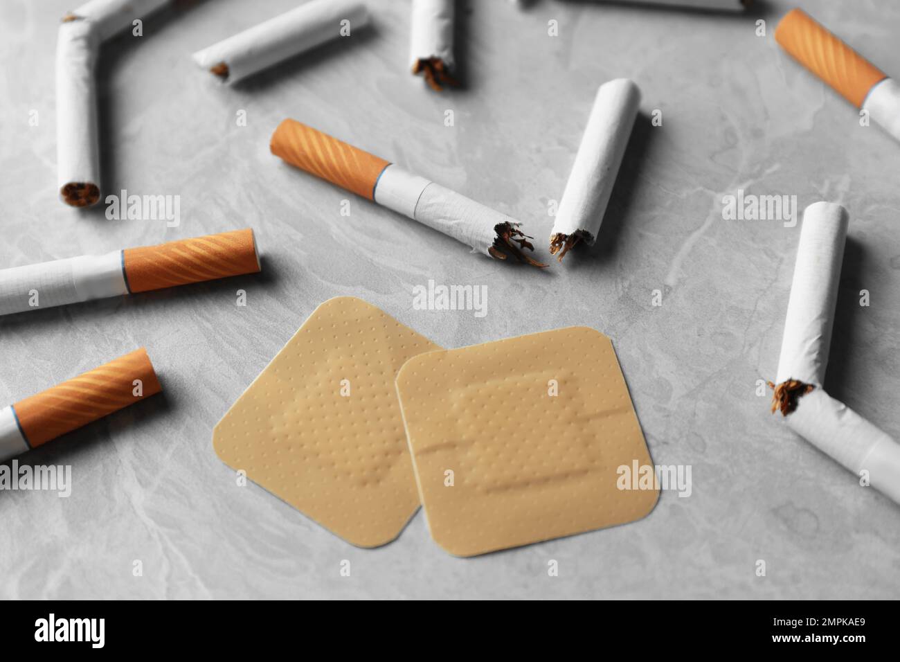 Nicotine patches and broken cigarettes on grey table Stock Photo - Alamy