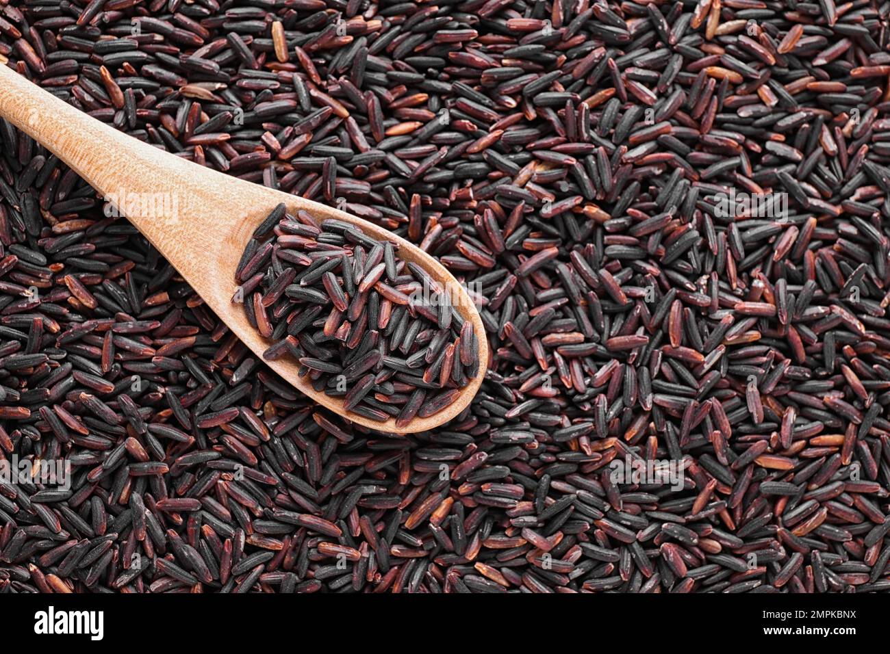 Pile of brown rice with spoon, top view. Space for text Stock Photo - Alamy