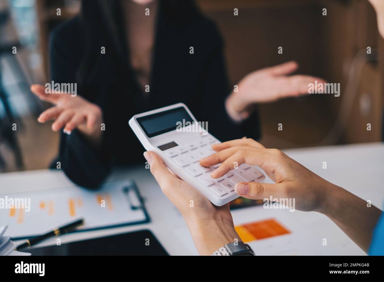 Asian Business Woman or Accountant do math and analyze with calculator ...