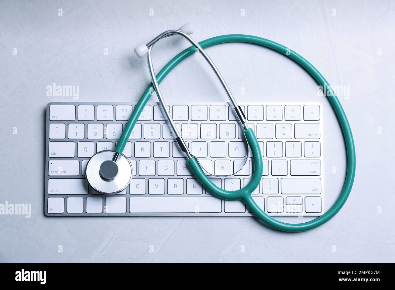 Keyboard and stethoscope on grey stone table, top view. Concept of ...
