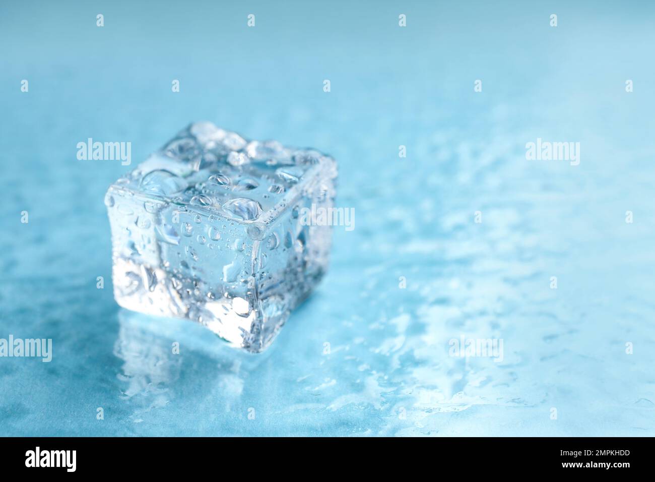 Crystal clear ice cube on light blue background, closeup. Space for text Stock Photo - Alamy