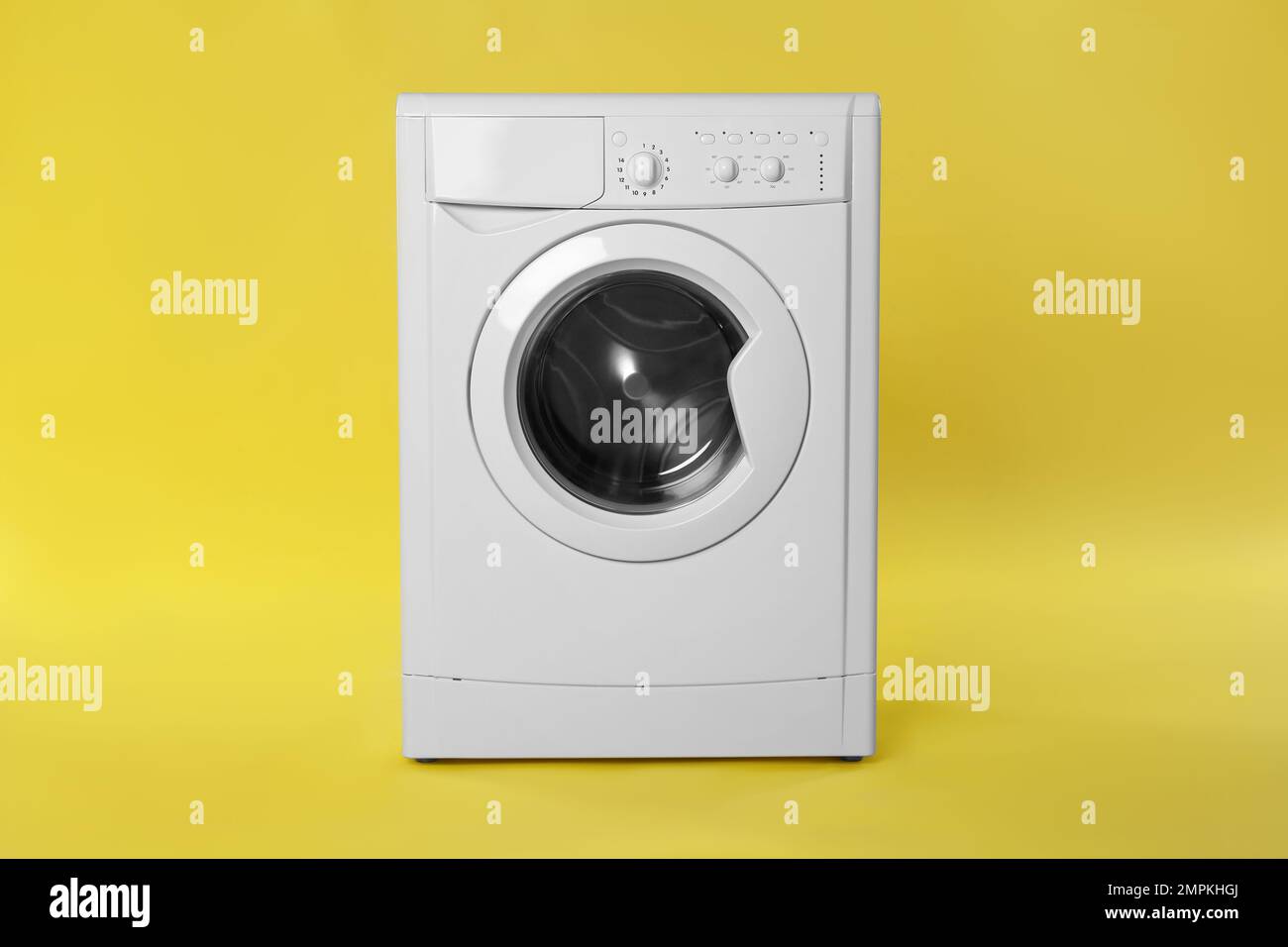 Modern washing machine on yellow background. Laundry day Stock Photo ...
