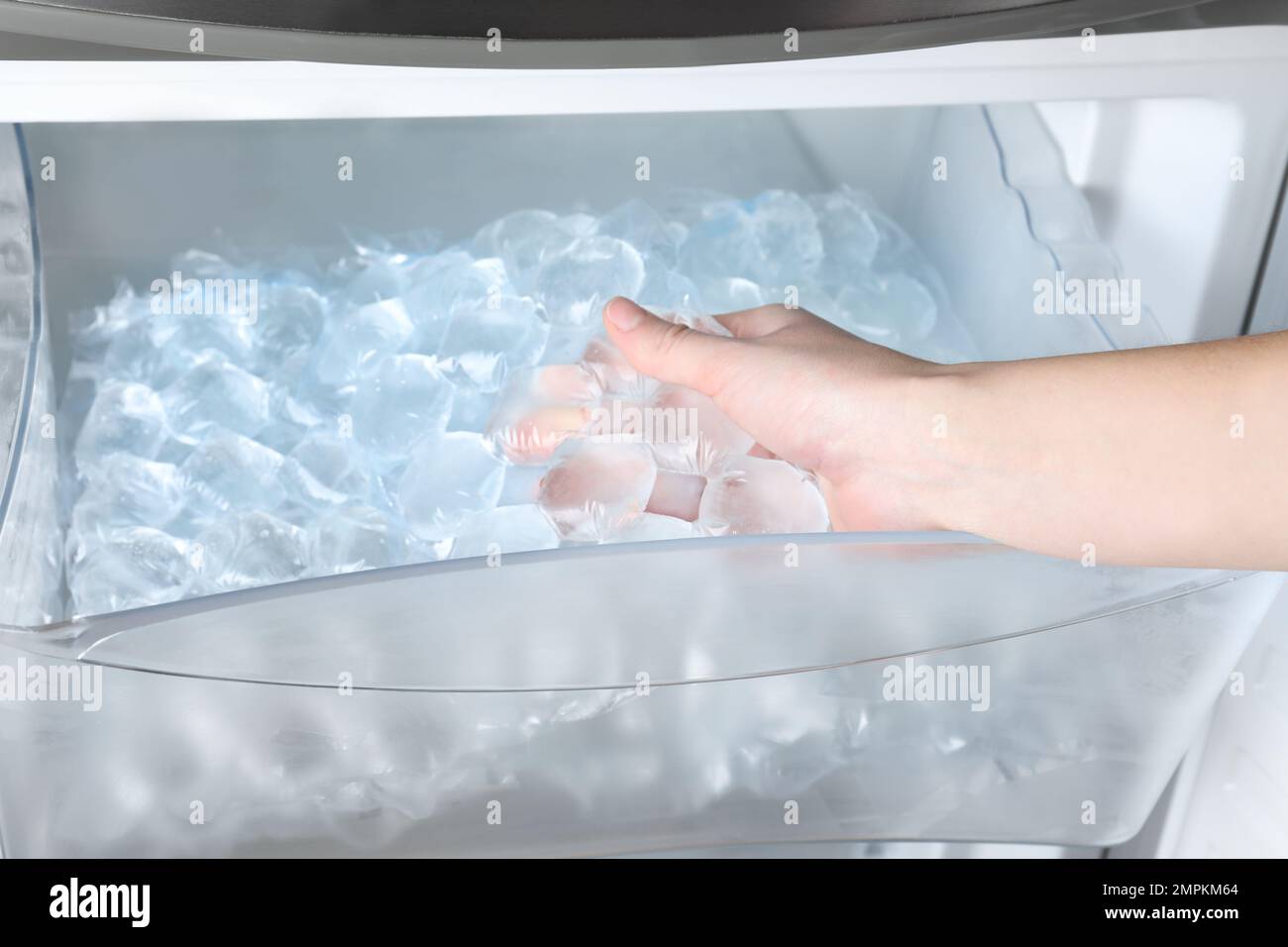 Woman taking plastic bag with ice cubes from fridge, closeup Stock ...