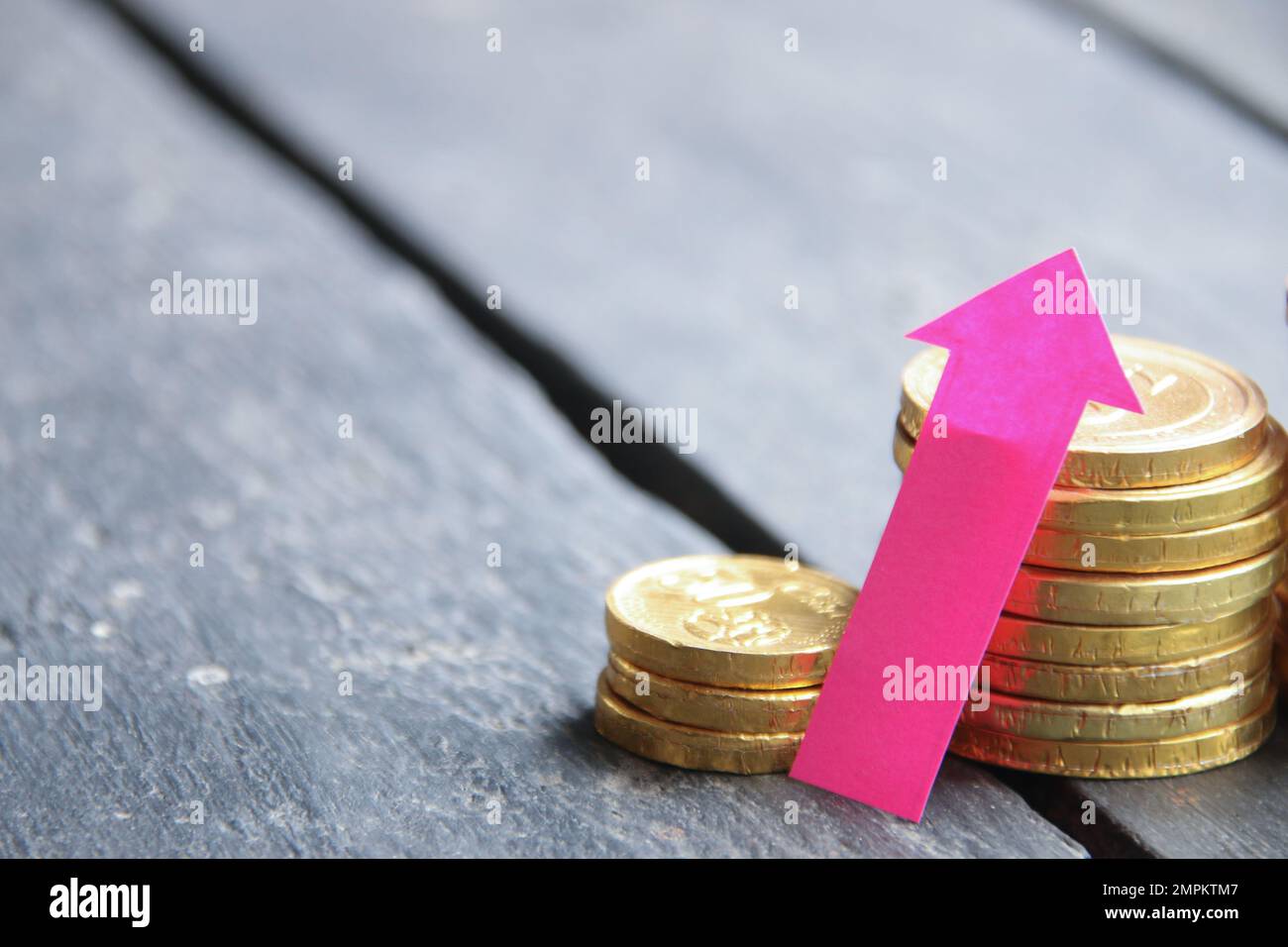 Stacks of gold coins with arrow Stock Photo - Alamy