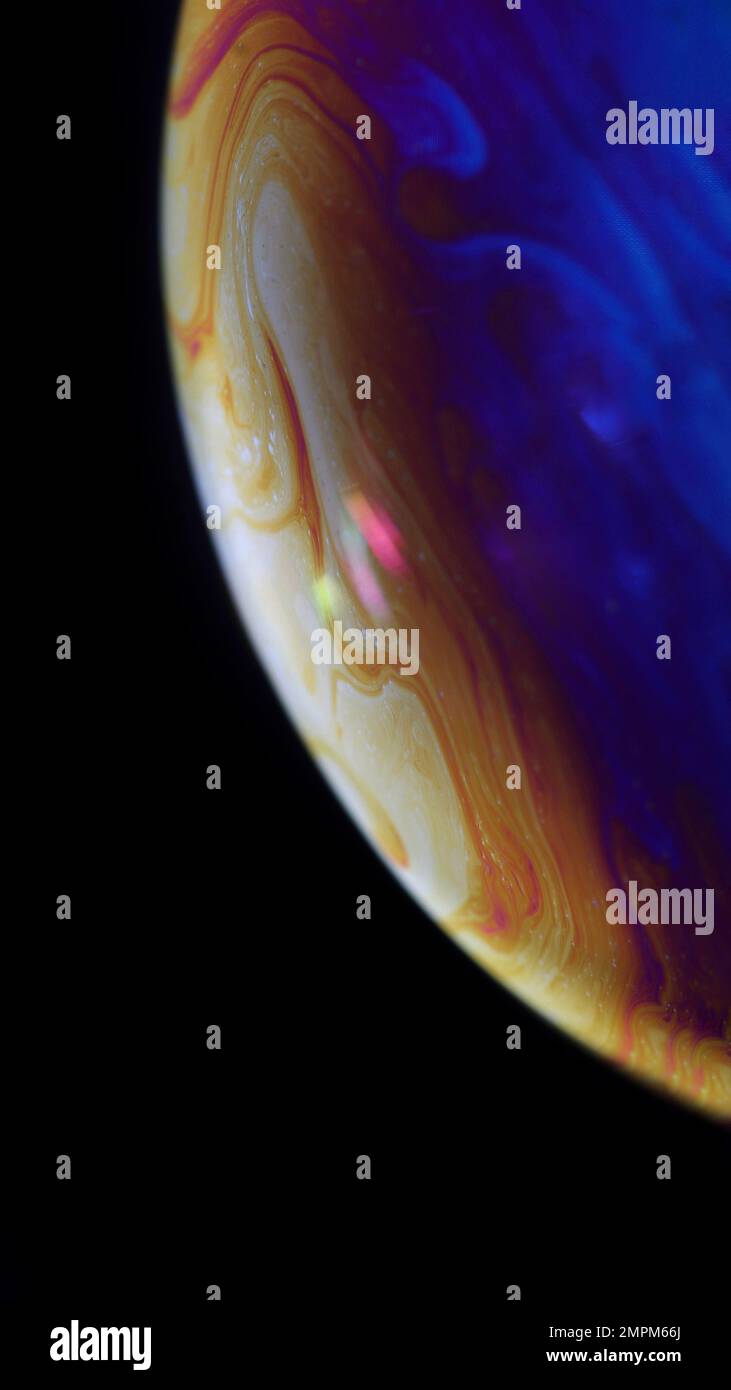 A macro vertical shot of colorful Soap bubble resembles a planet ...