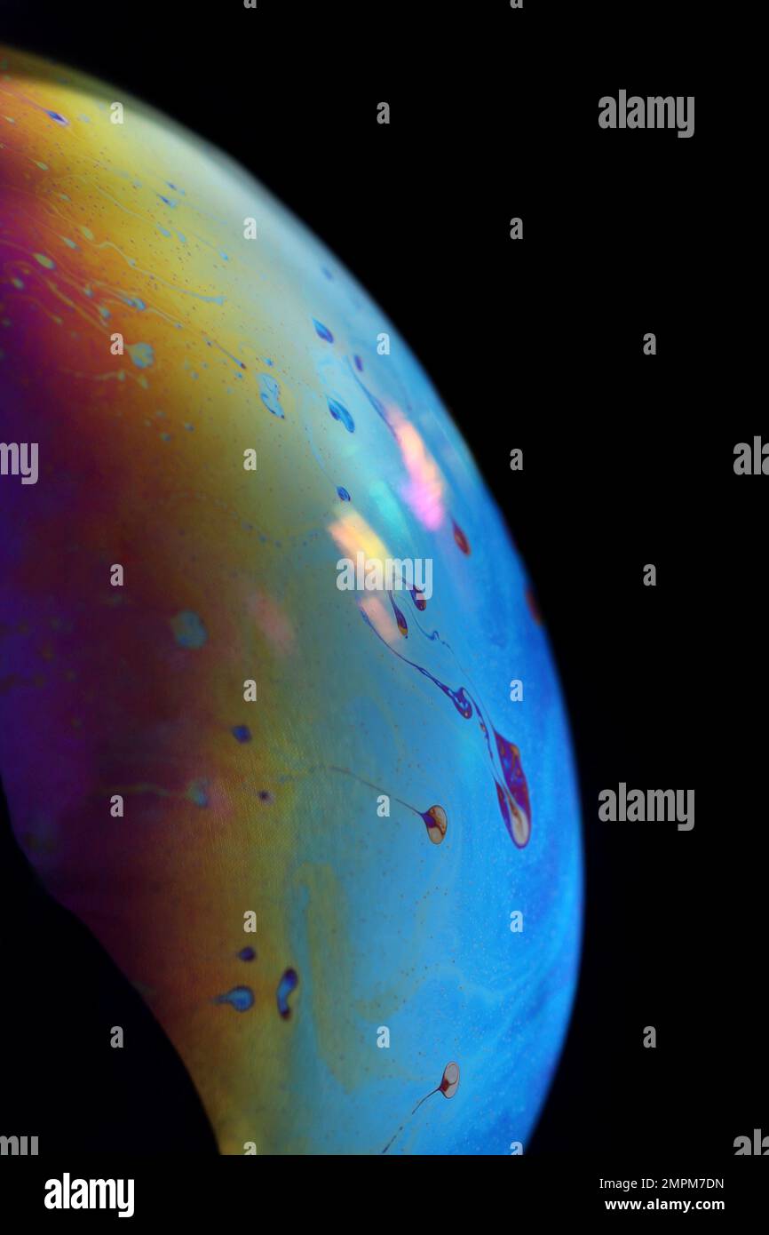 A macro vertical shot of colorful Soap bubble resembles a planet ...