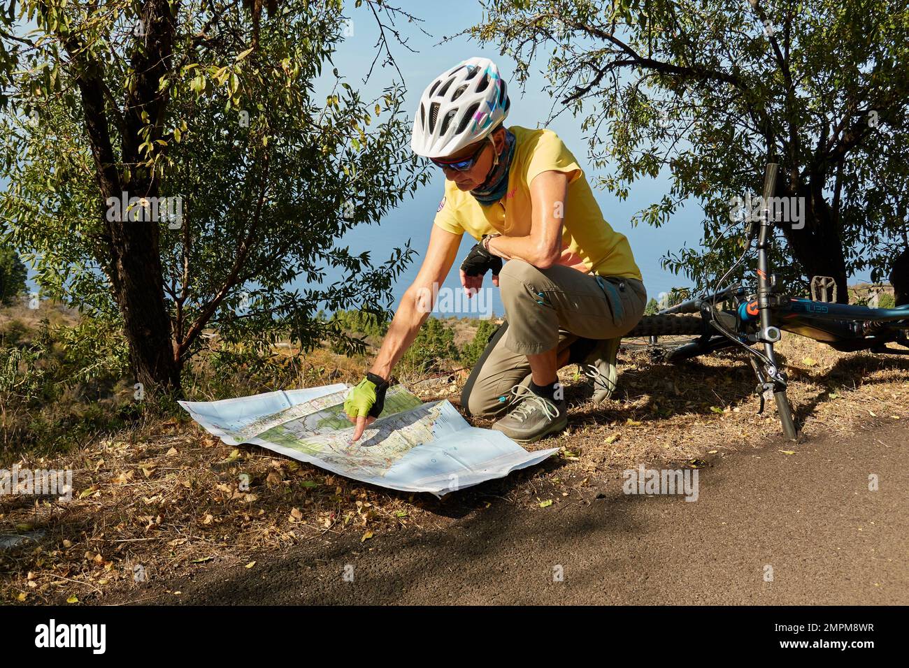 A view of the biker using the map in the mountains Stock Photo - Alamy