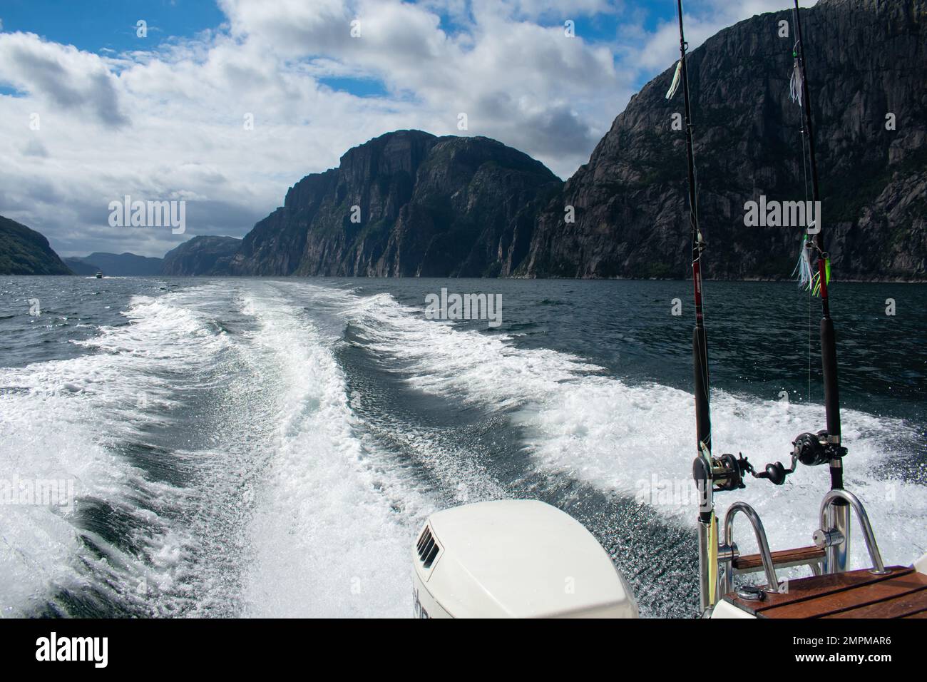 Boat with fish rods and gear with scenic mountains / fjords in the ...