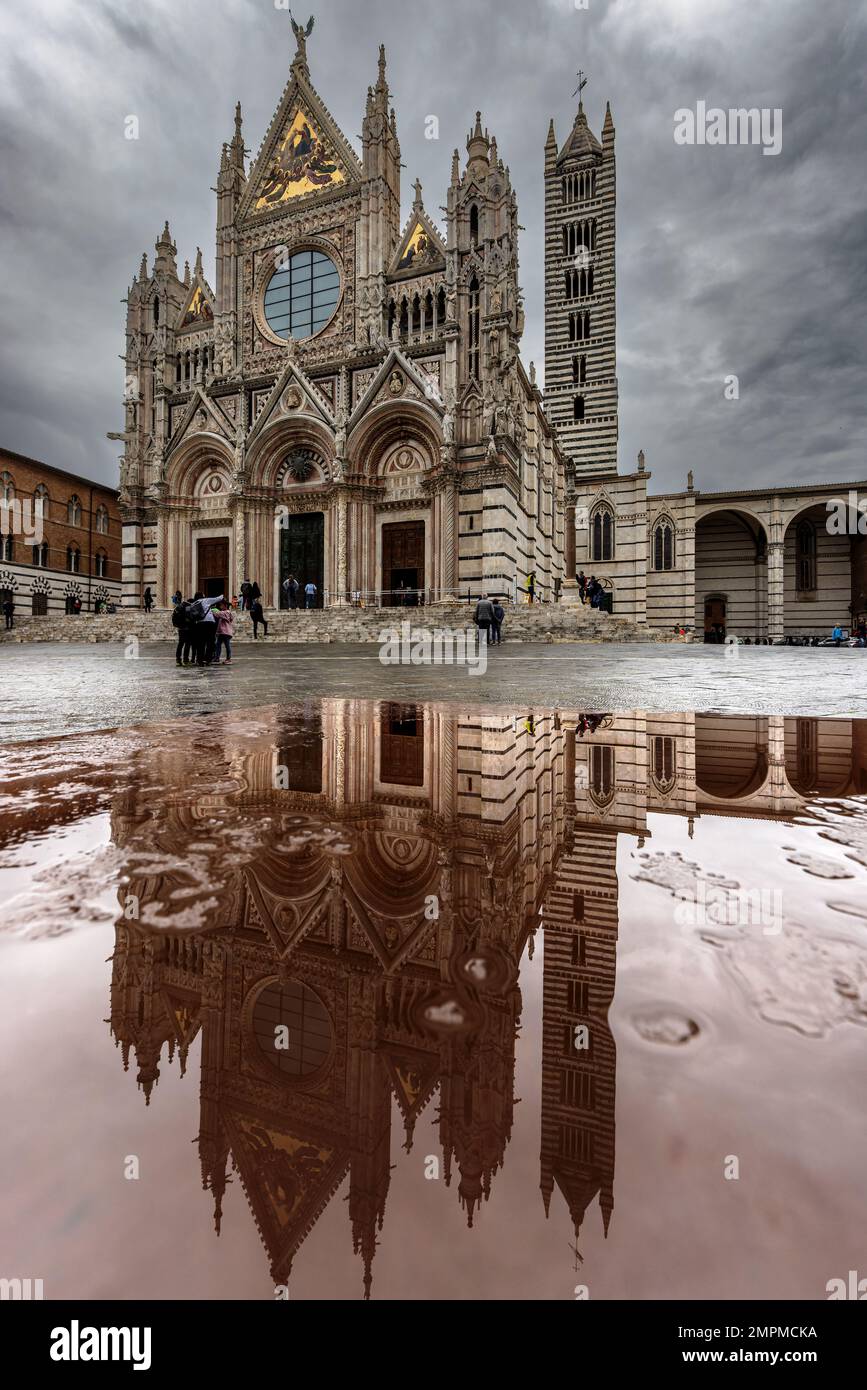 Siena Cathedral with reflection in a puddle in Siena, Tuscany, Italy ...