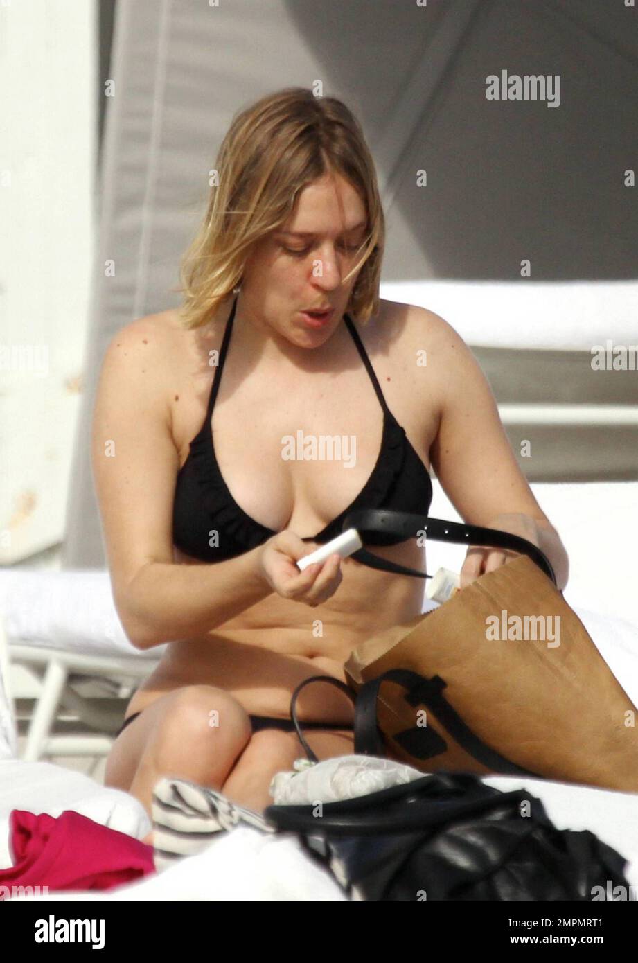 Chloe Sevigny applies suntan lotion while relaxing on the beach with friends. The actress ...