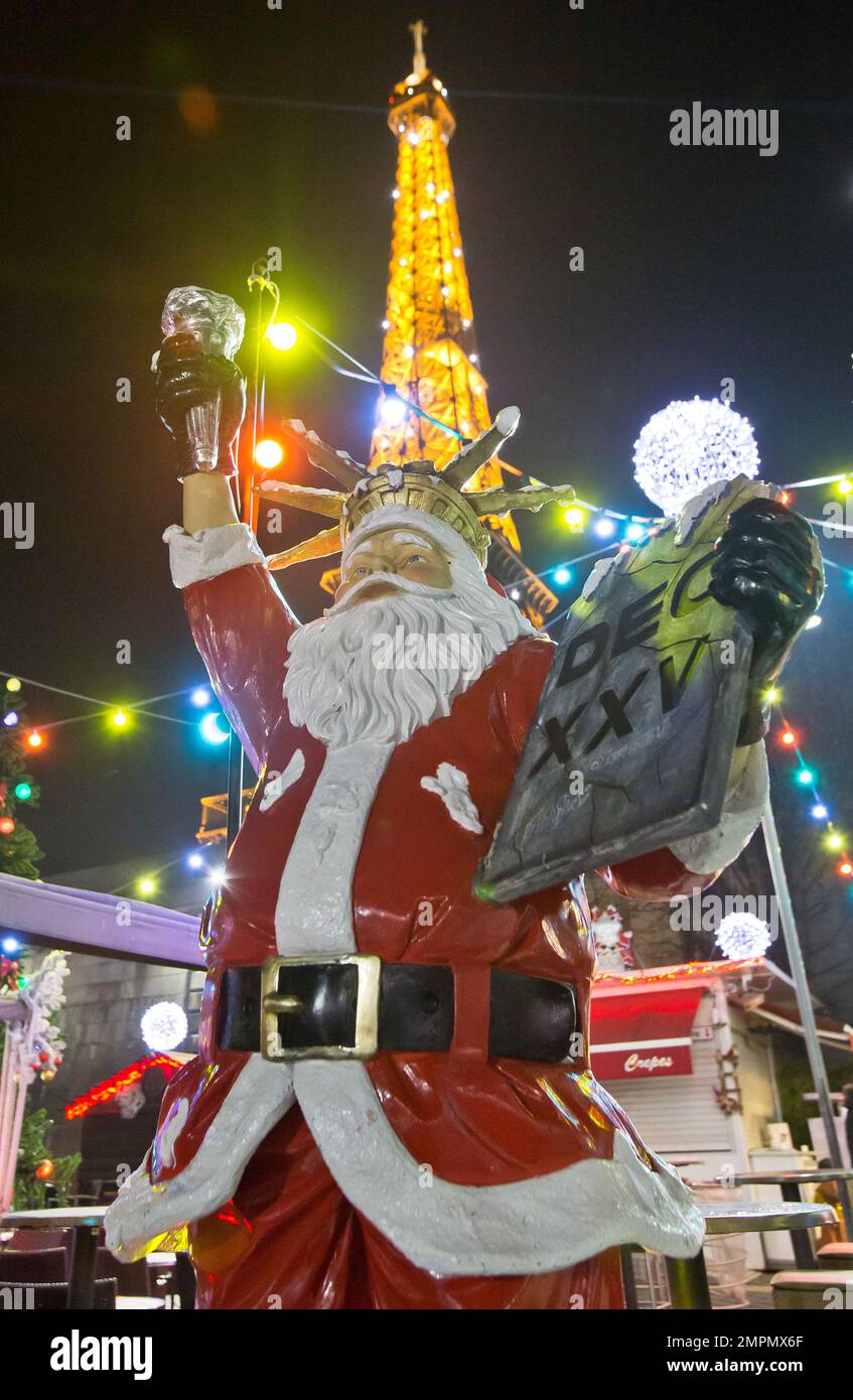 A Santa Claus model is displayed next to the Eiffel tower along the ...
