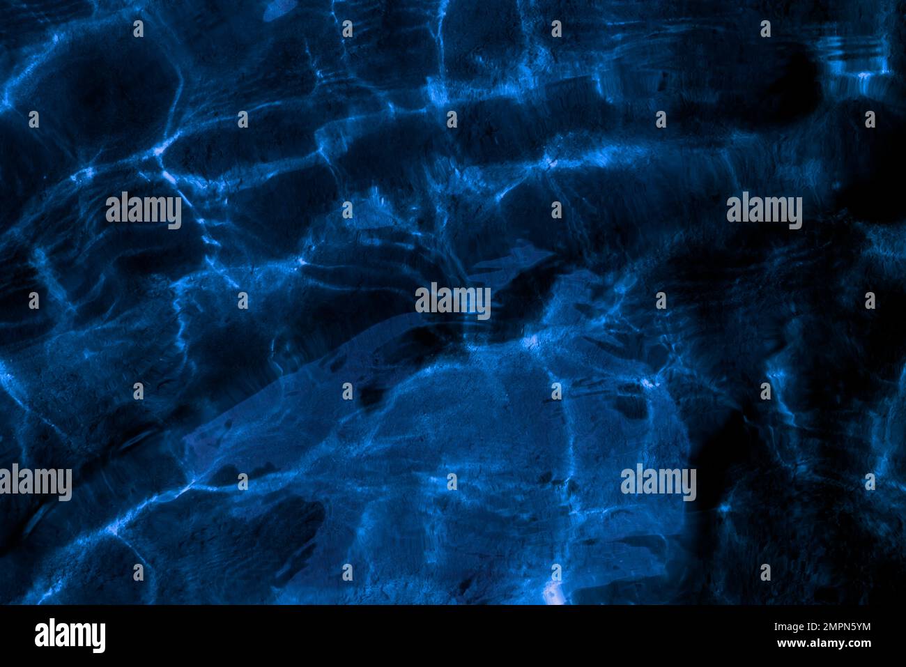 Abstract photo of a glowing water surface with blue light reflecting ...