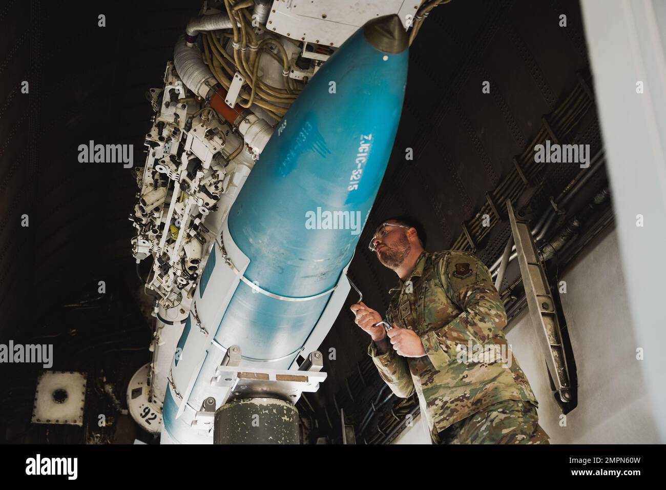Senior Airmen Nolan Denney, 28th Aircraft Maintenance Squadron weapons load crew member, fastens ...