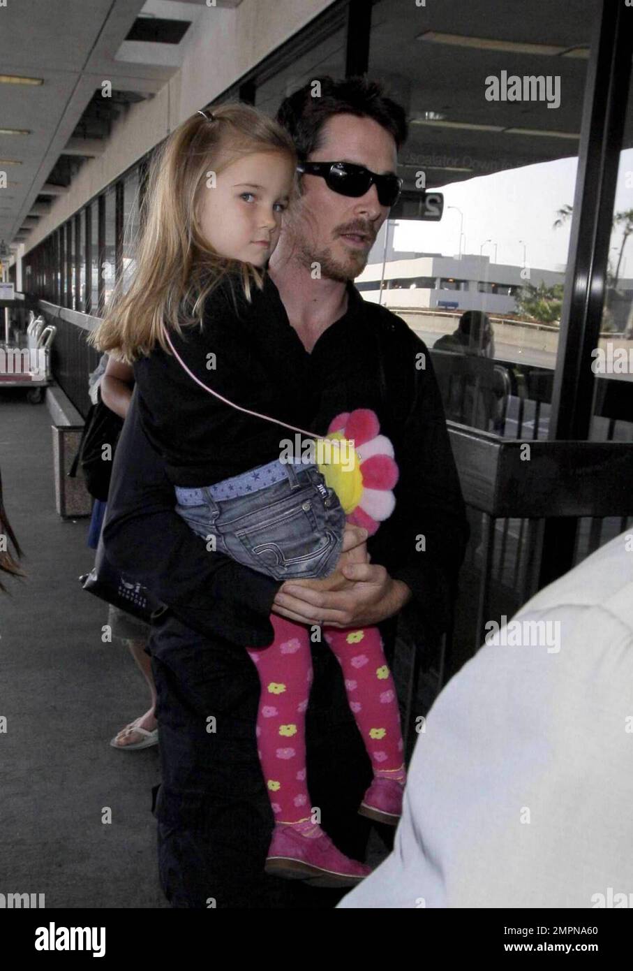 Actor Christian Bale carries his daughter Emmeline as he arrives with ...