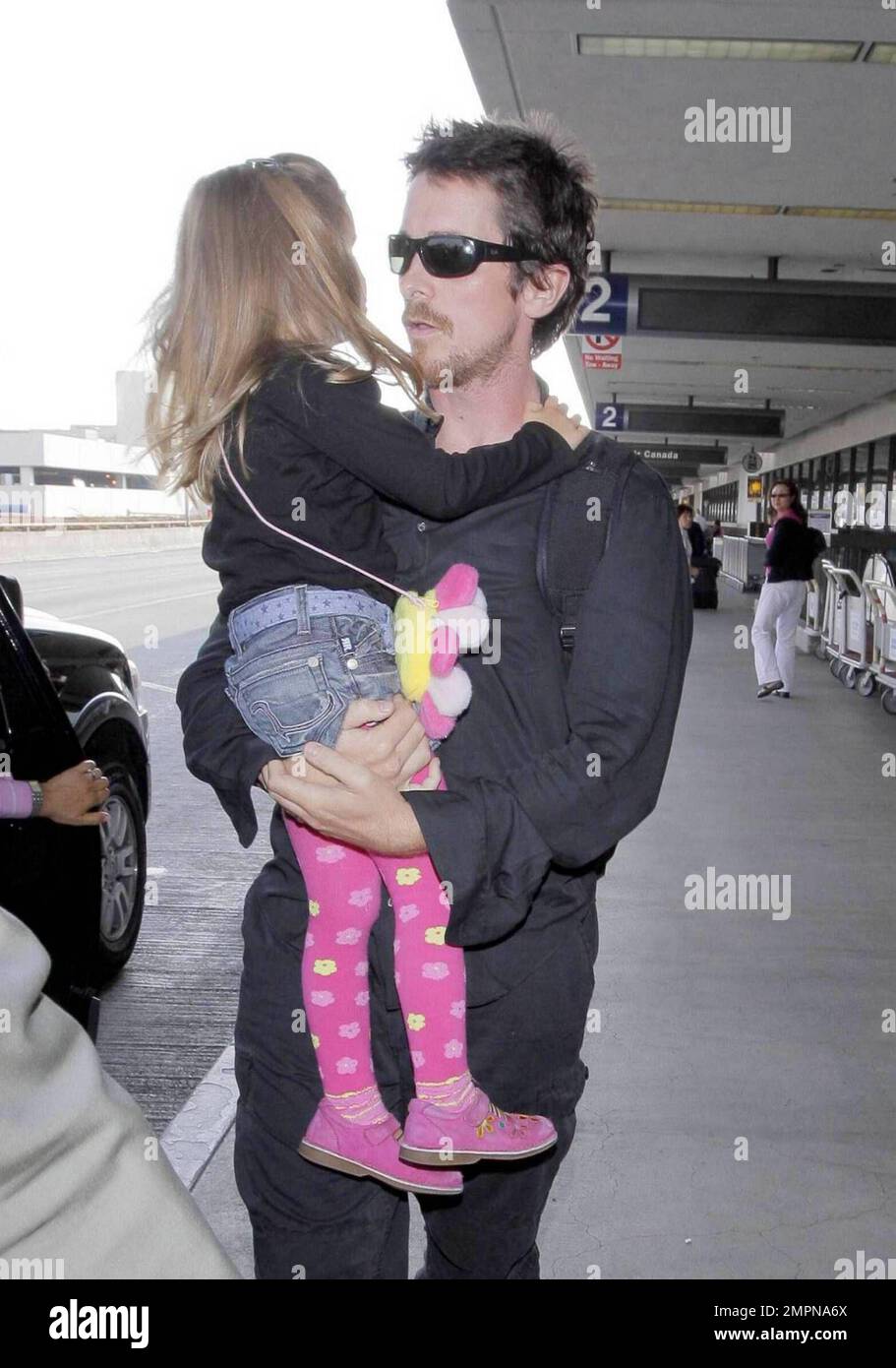 Actor Christian Bale carries his daughter Emmeline as he arrives with ...