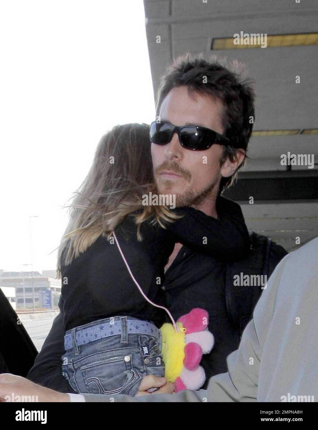Actor Christian Bale carries his daughter Emmeline as he arrives with ...