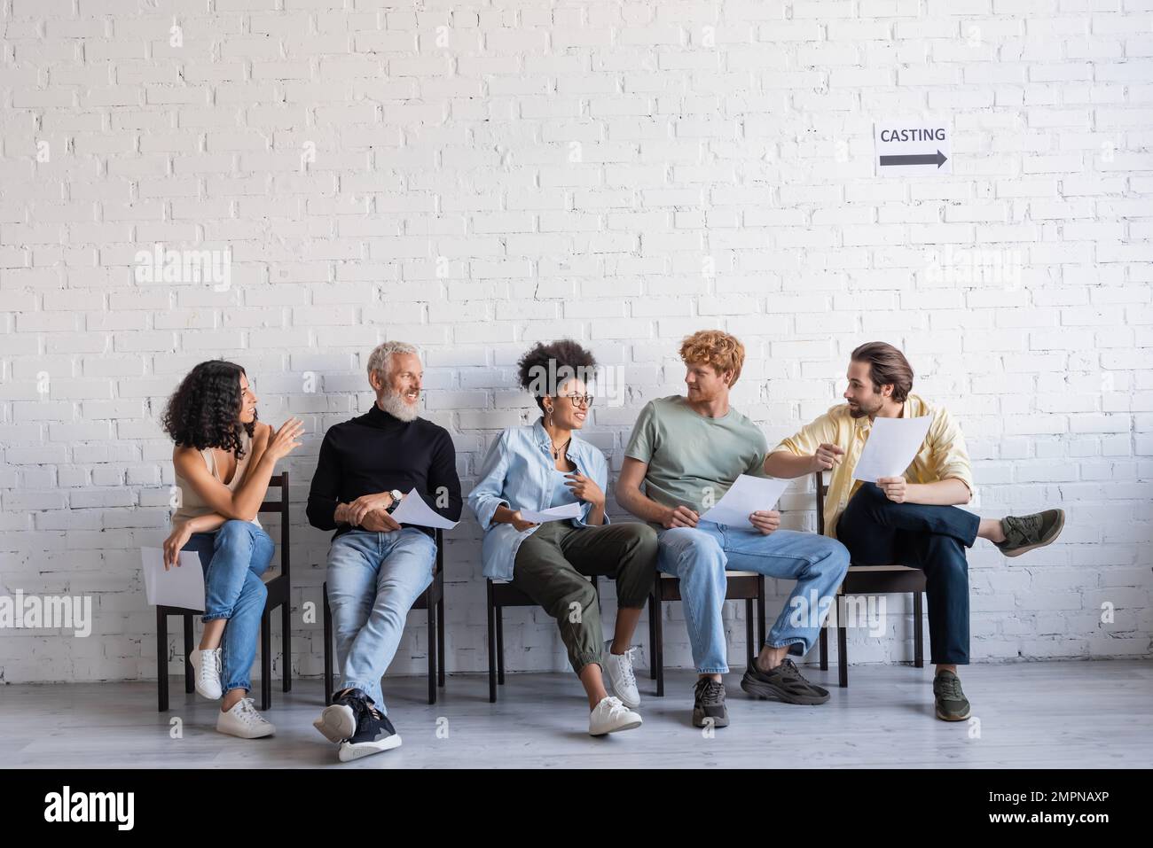 positive multicultural actors holding screenplays and talking while ...