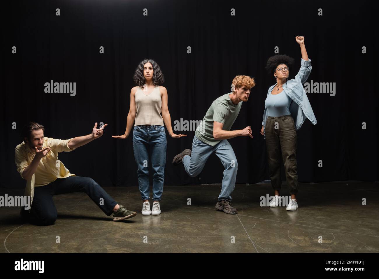 full length of young multiethnic actors rehearsing in different poses ...