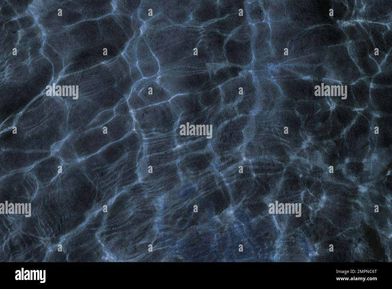 Abstract photo of a glowing water surface with blue light reflecting ...