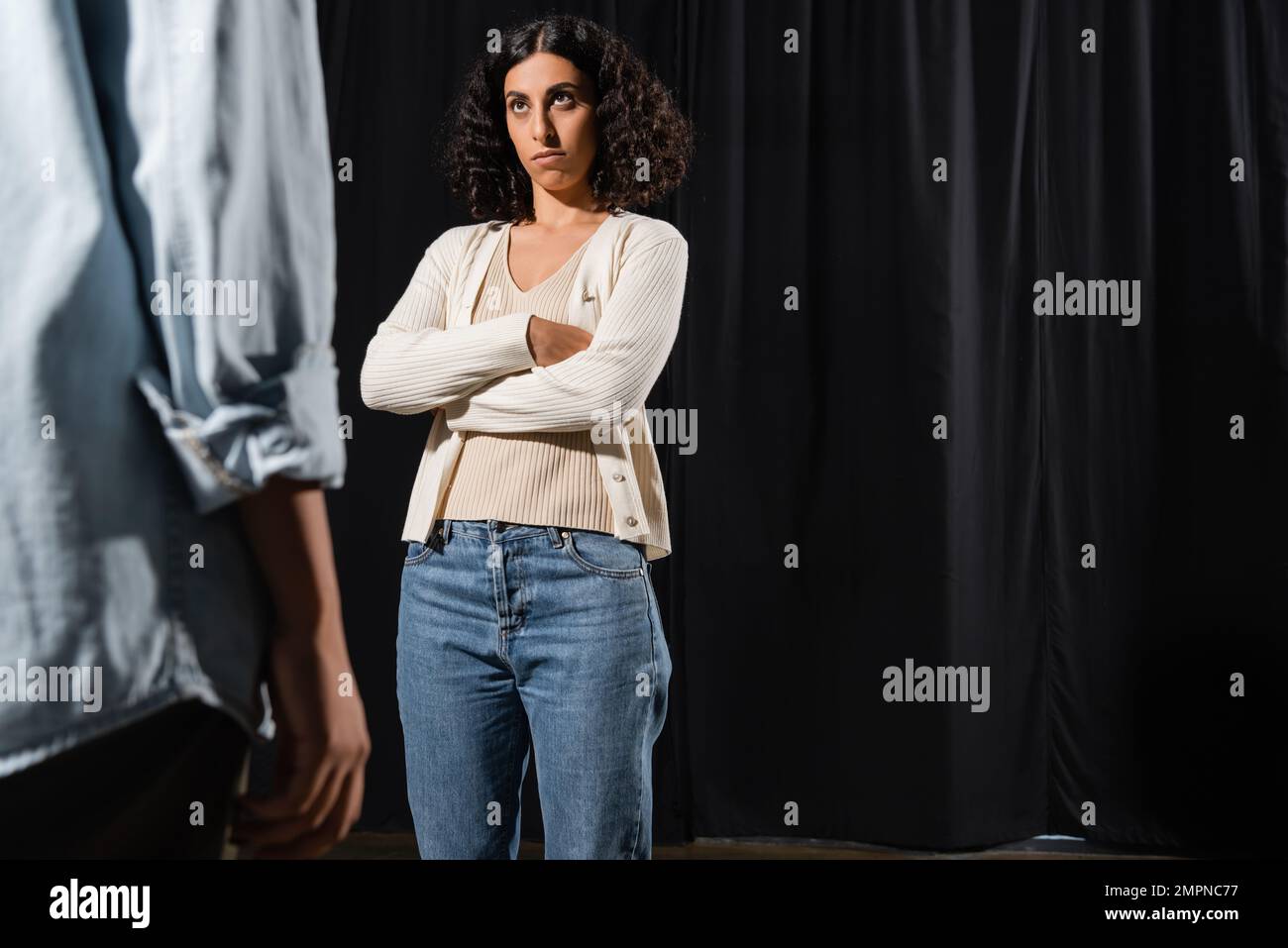 multiracial actress with displeased face expression standing with ...
