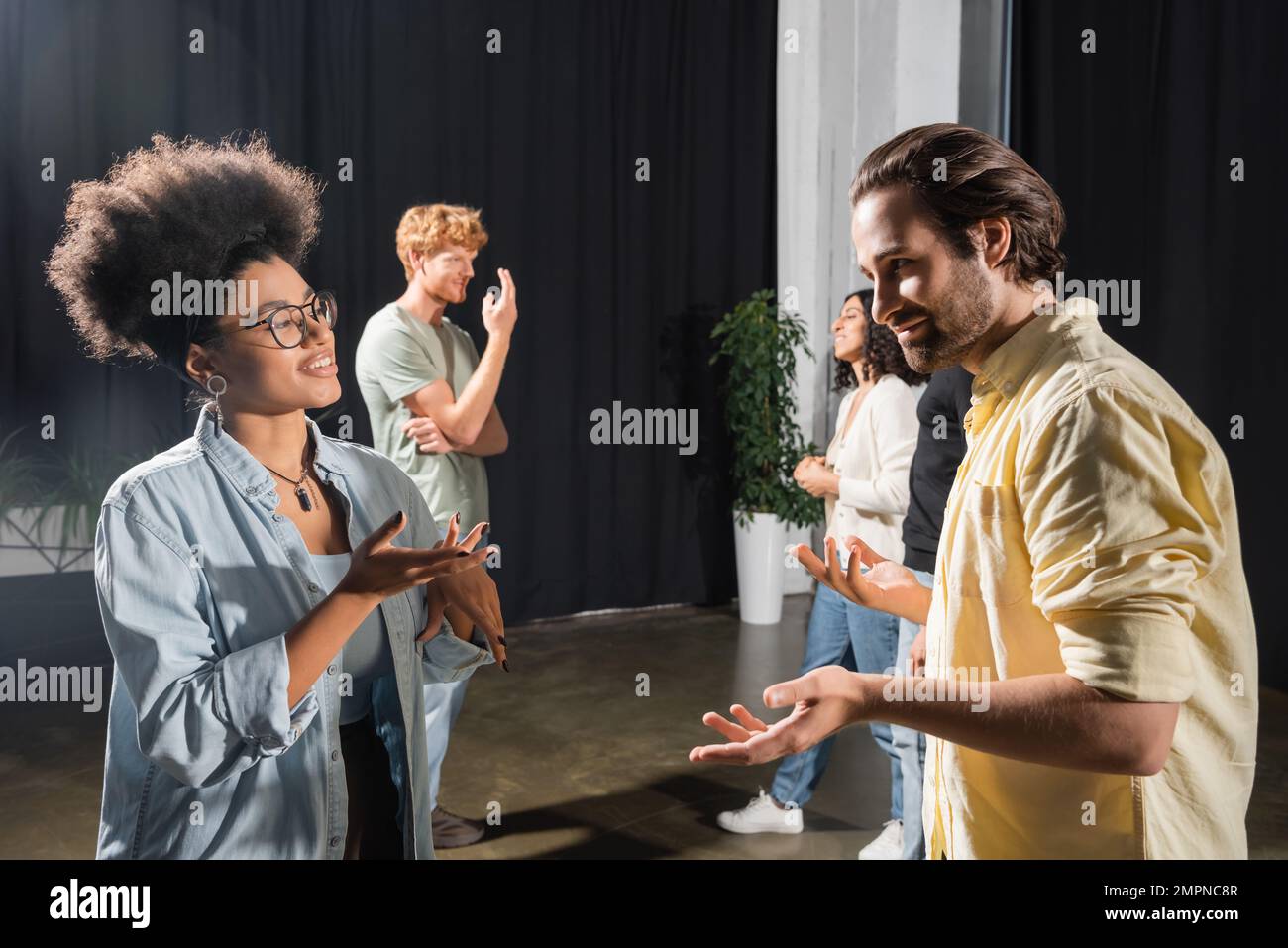 smiling multiethnic actors gesturing during conversation in acting ...