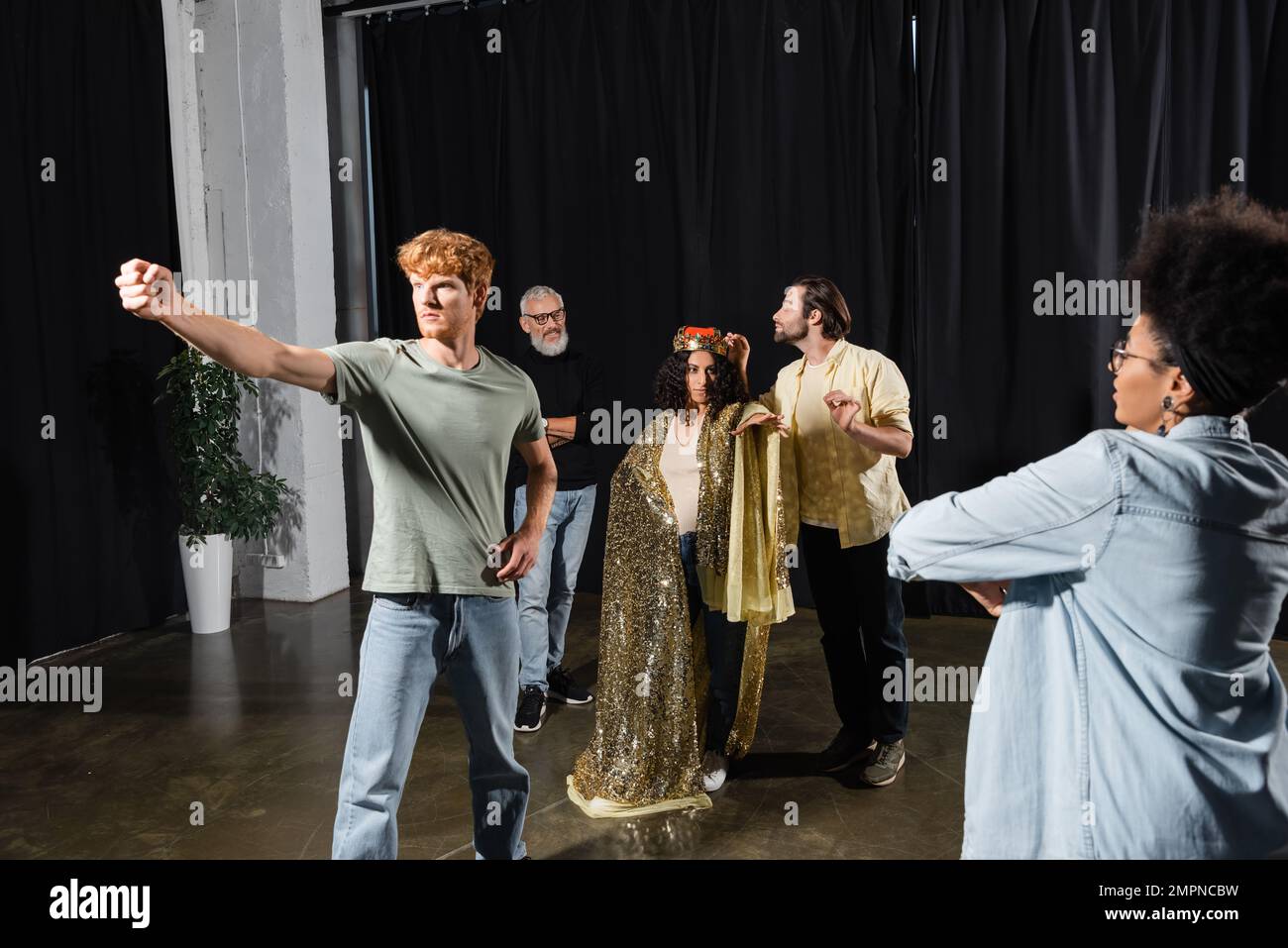 multiracial woman in queen costume and redhead man with outstretched ...