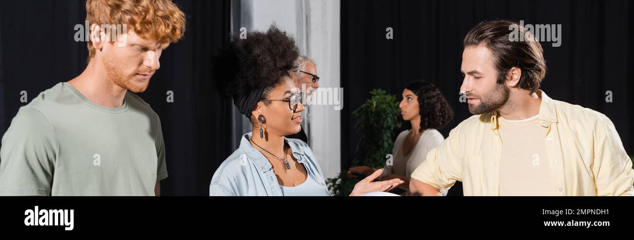 happy african american woman talking to bearded actor near interracial ...