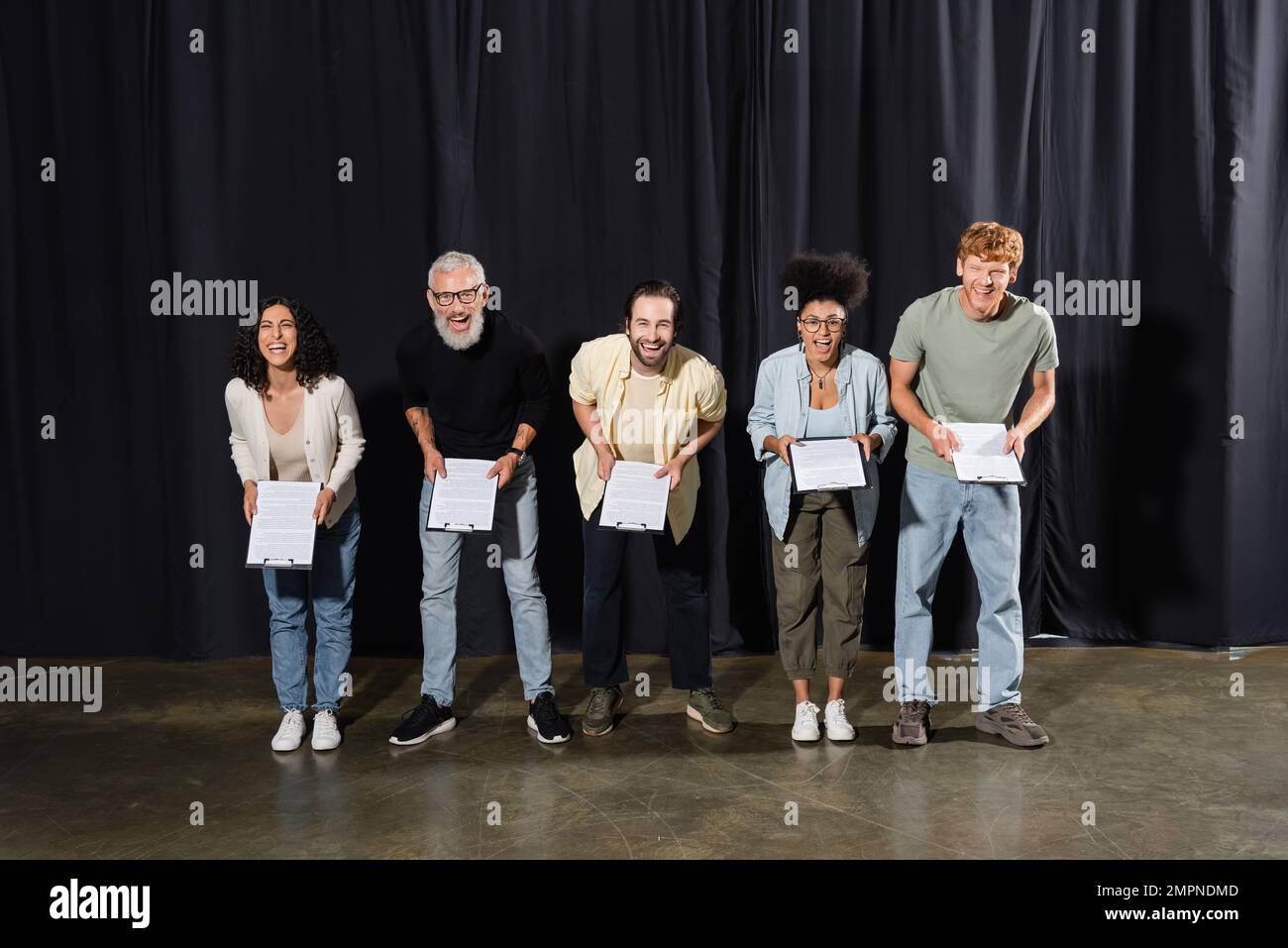 excited actors with bearded screenwriter looking at camera and laughing ...
