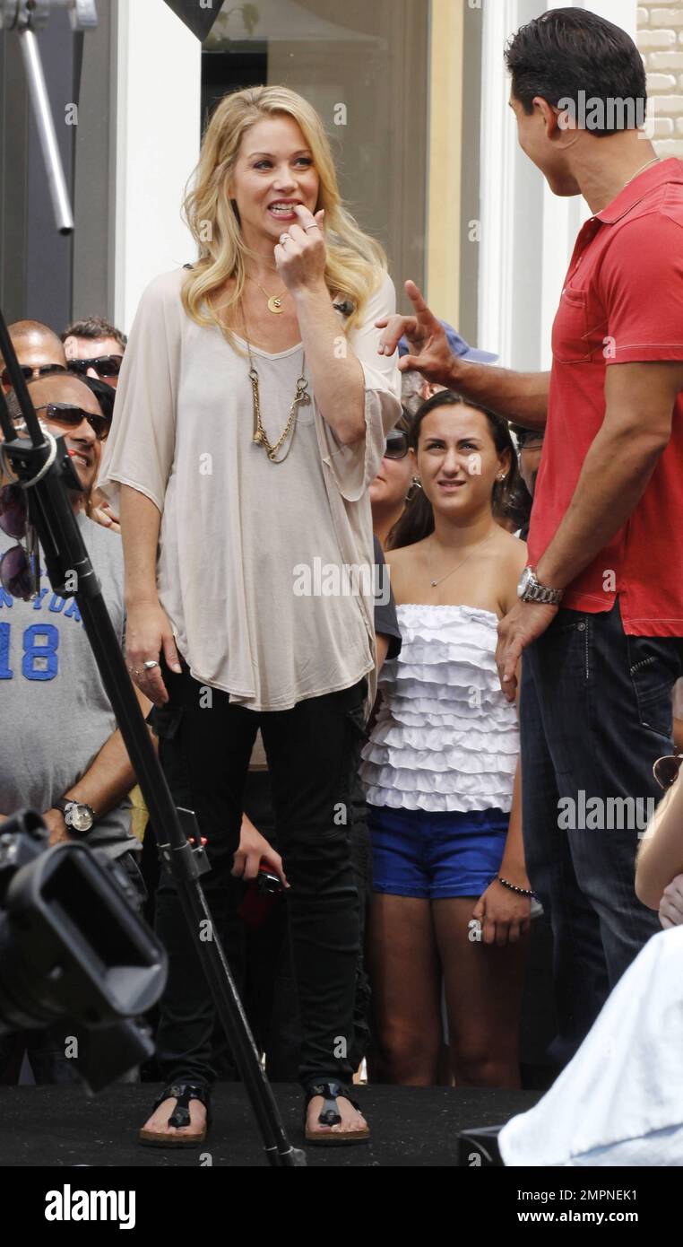 Wearing a loose tan top with black skinny jeans and sandals, Christina ...